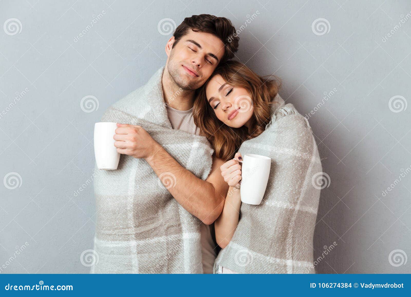 Portrait Of A Lovely Happy Couple Standing Wrapped In Blanket Stock