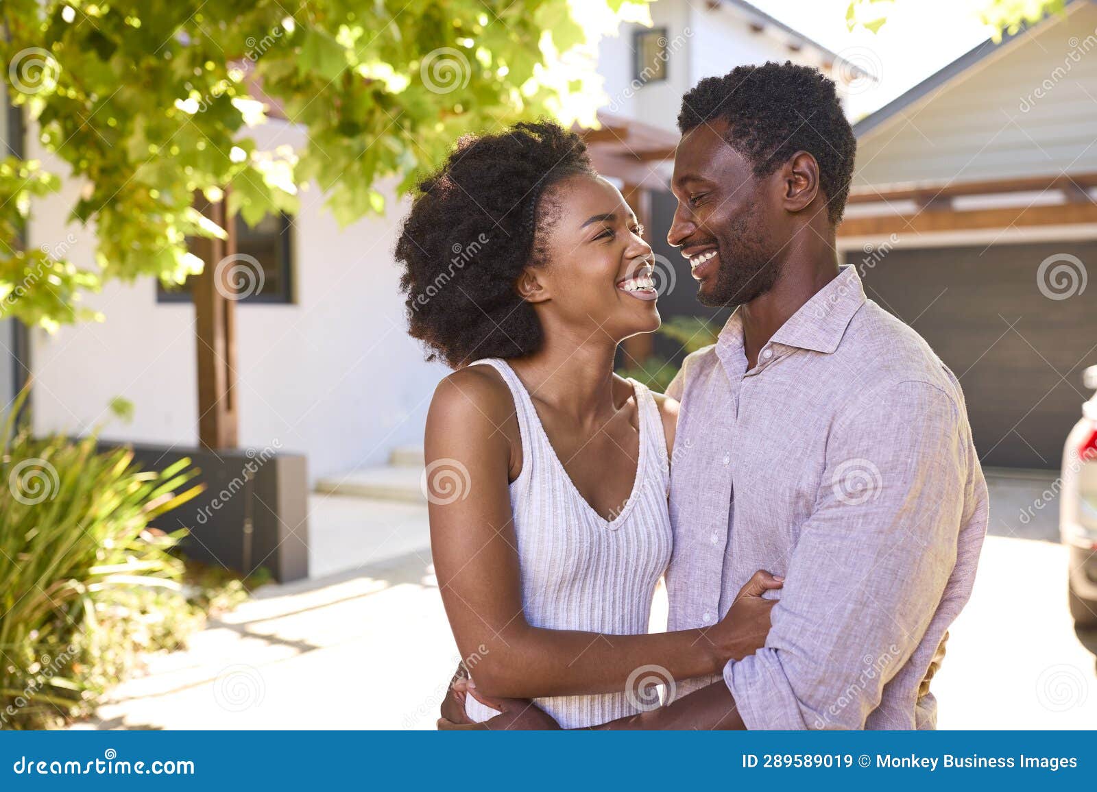 Portrait of Loving Couple Outdoors Hugging in Front of Home Stock Image ...