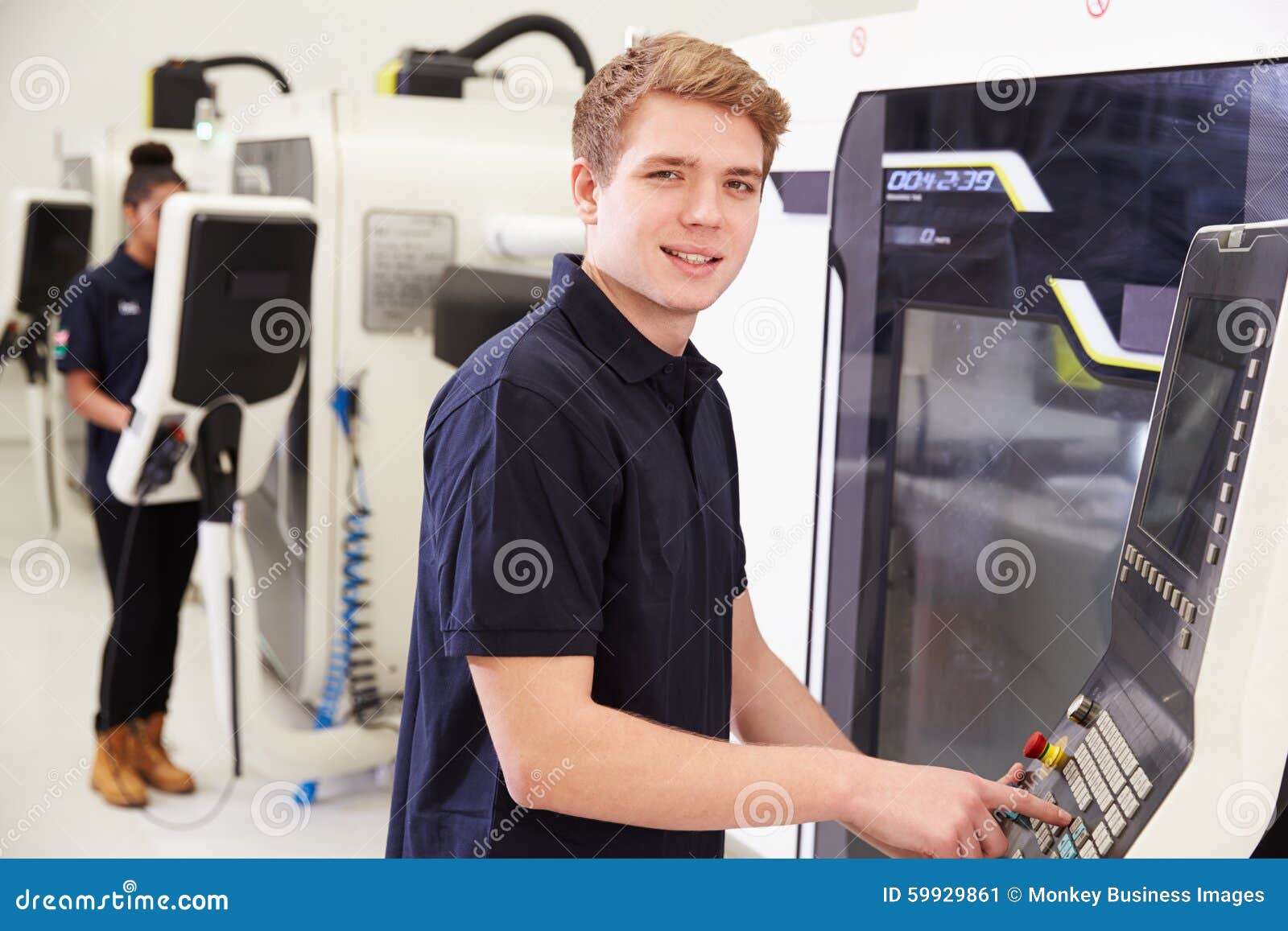 Portrait Of Male Engineer Operating Cnc Machinery In Factory Stock