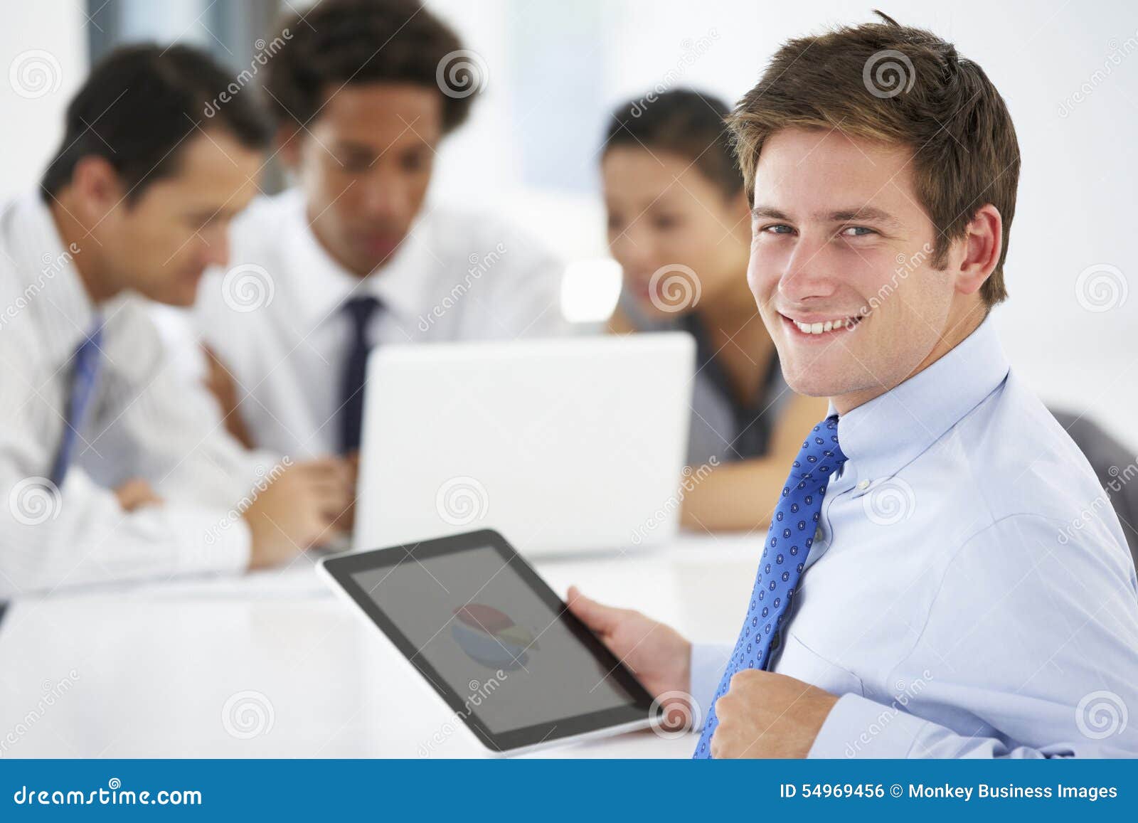 Portrait of Male Executive Using Tablet Computer with Office Meeting in ...