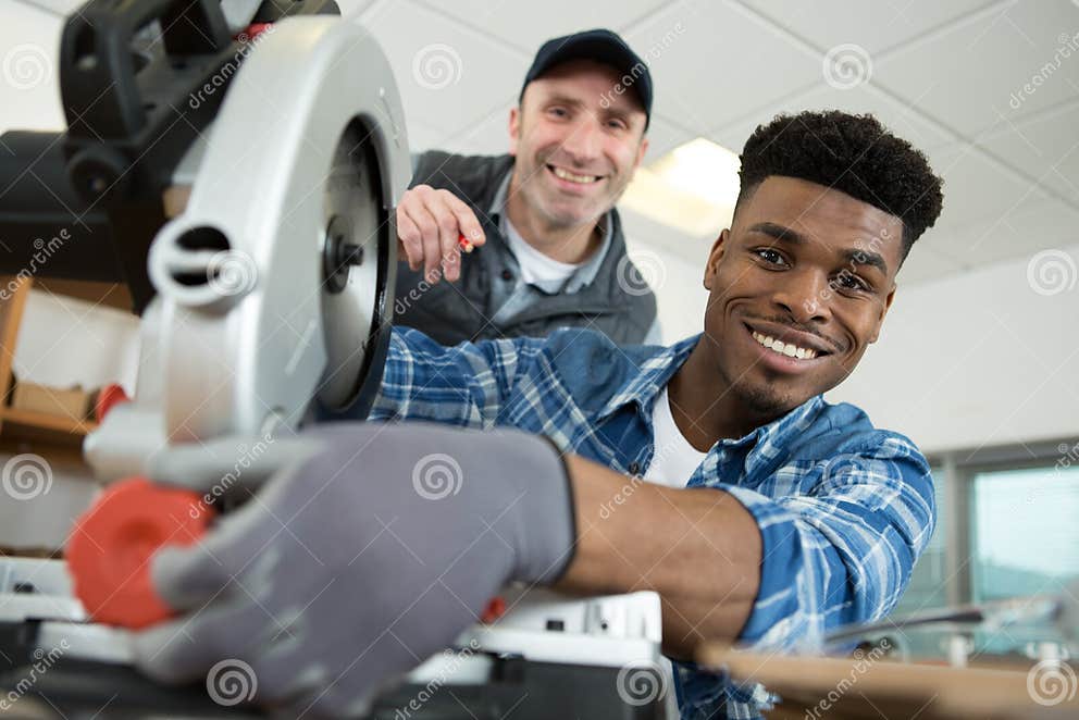 Portrait Male Supervisor Stood Behind Apprentice Using Circular Saw ...