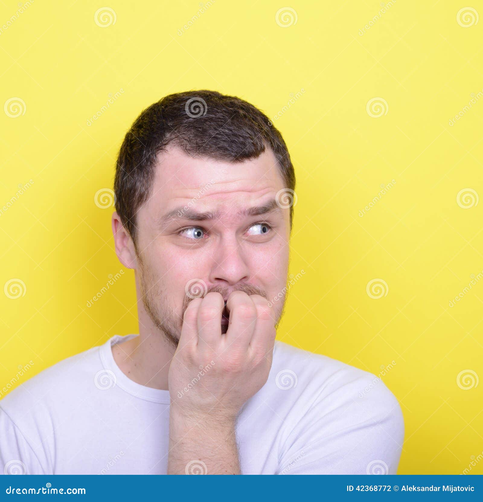 Portrait of Man Biting Nails Against Yellow Background Stock Photo ...