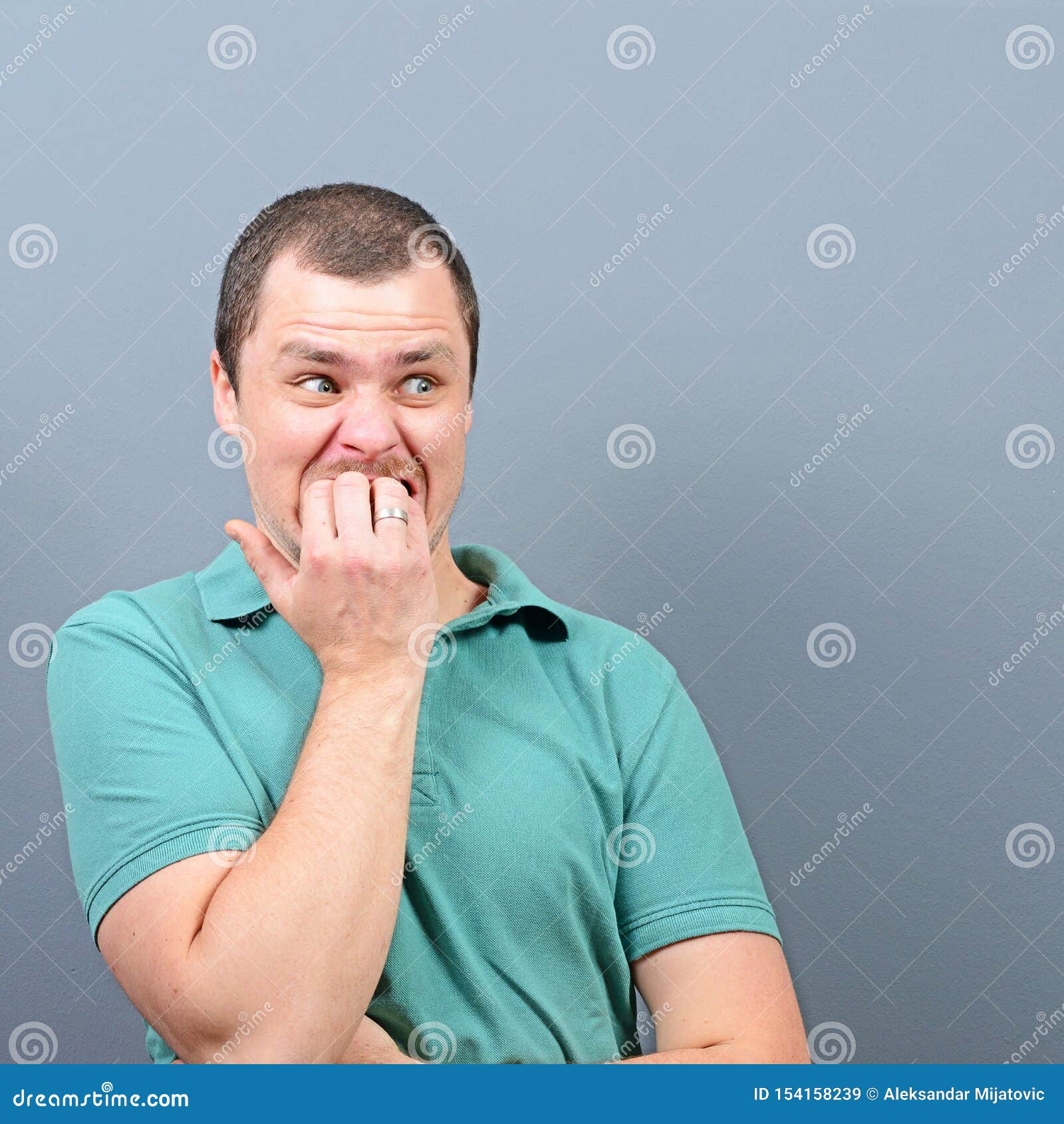 Portrait of a Man Biting Nails and Being Scared Against Gray Background ...