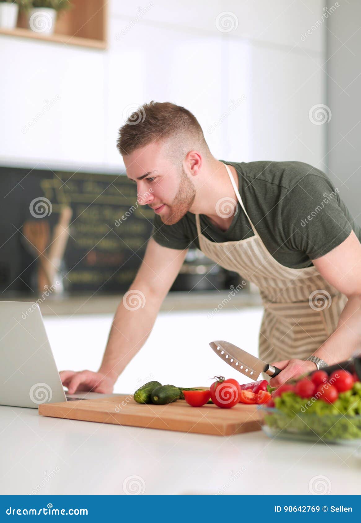 Portrait of Man Cooking Vegetable in the Kitchen while Looking at a ...