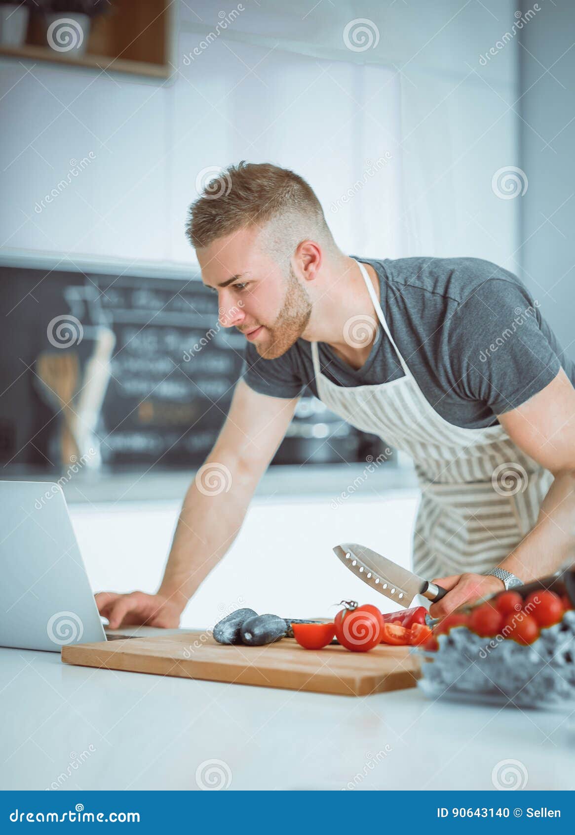 Portrait of Man Cooking Vegetable in the Kitchen while Looking at a ...