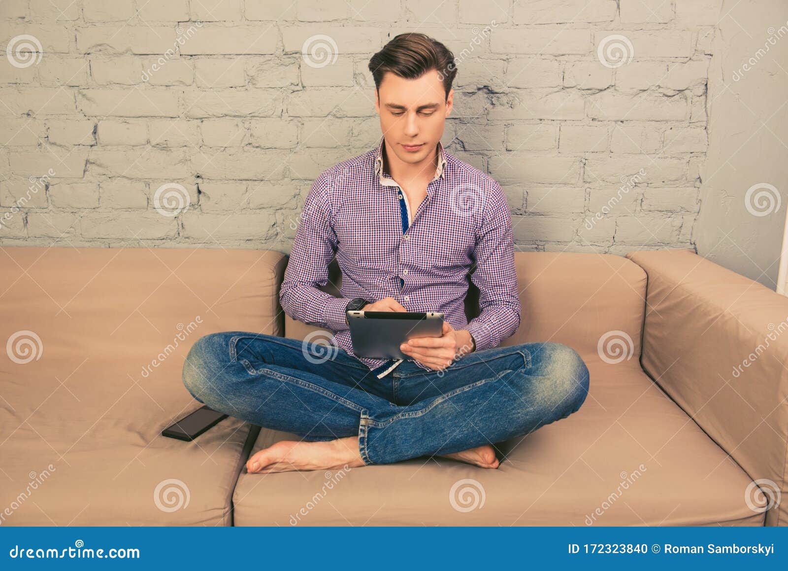 Portrait of Man Sitting on Couch and Using Digital Tablet Stock Photo ...