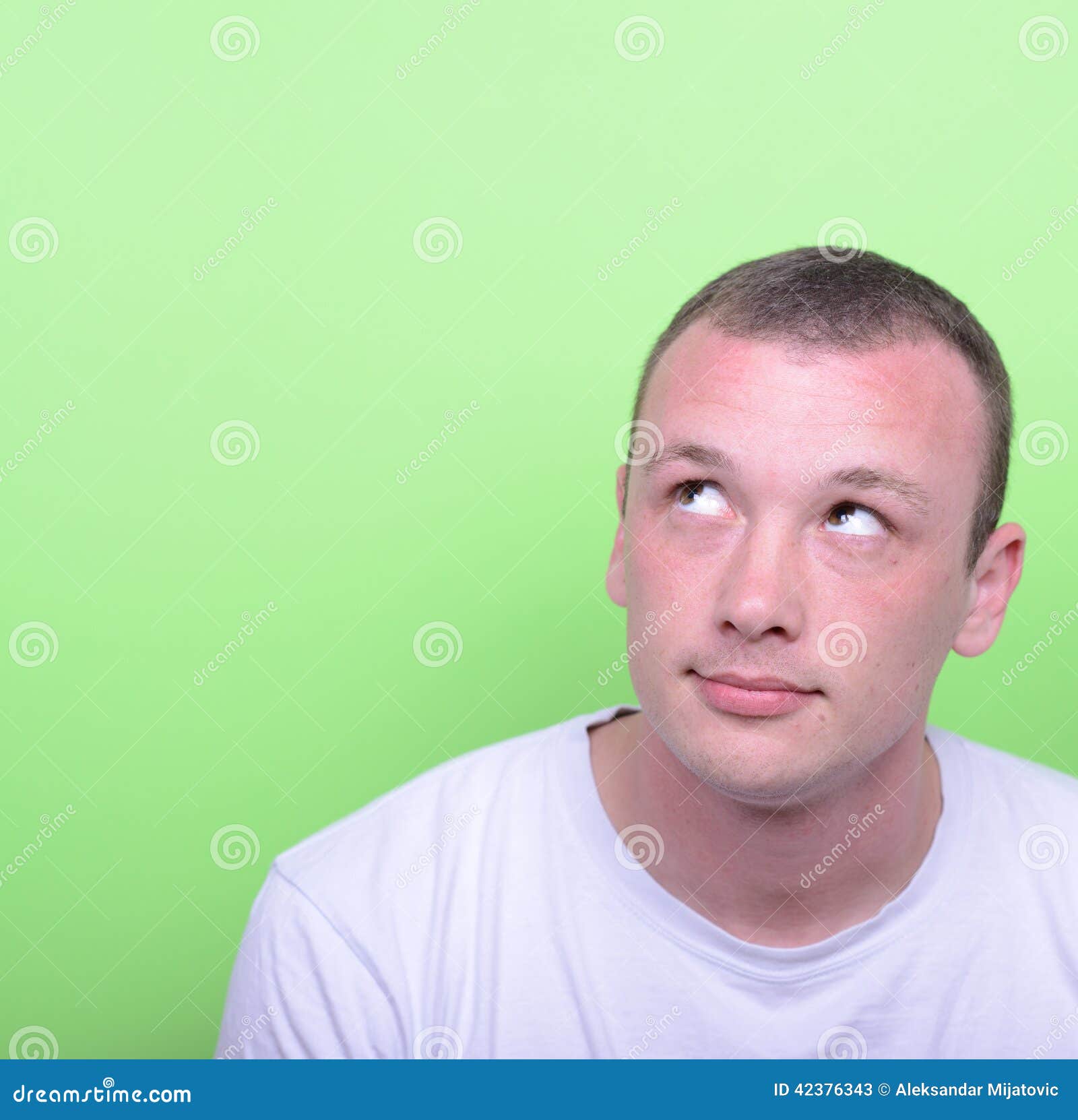 Portrait of Man Thinking and Looking Up Against Green Background Stock ...