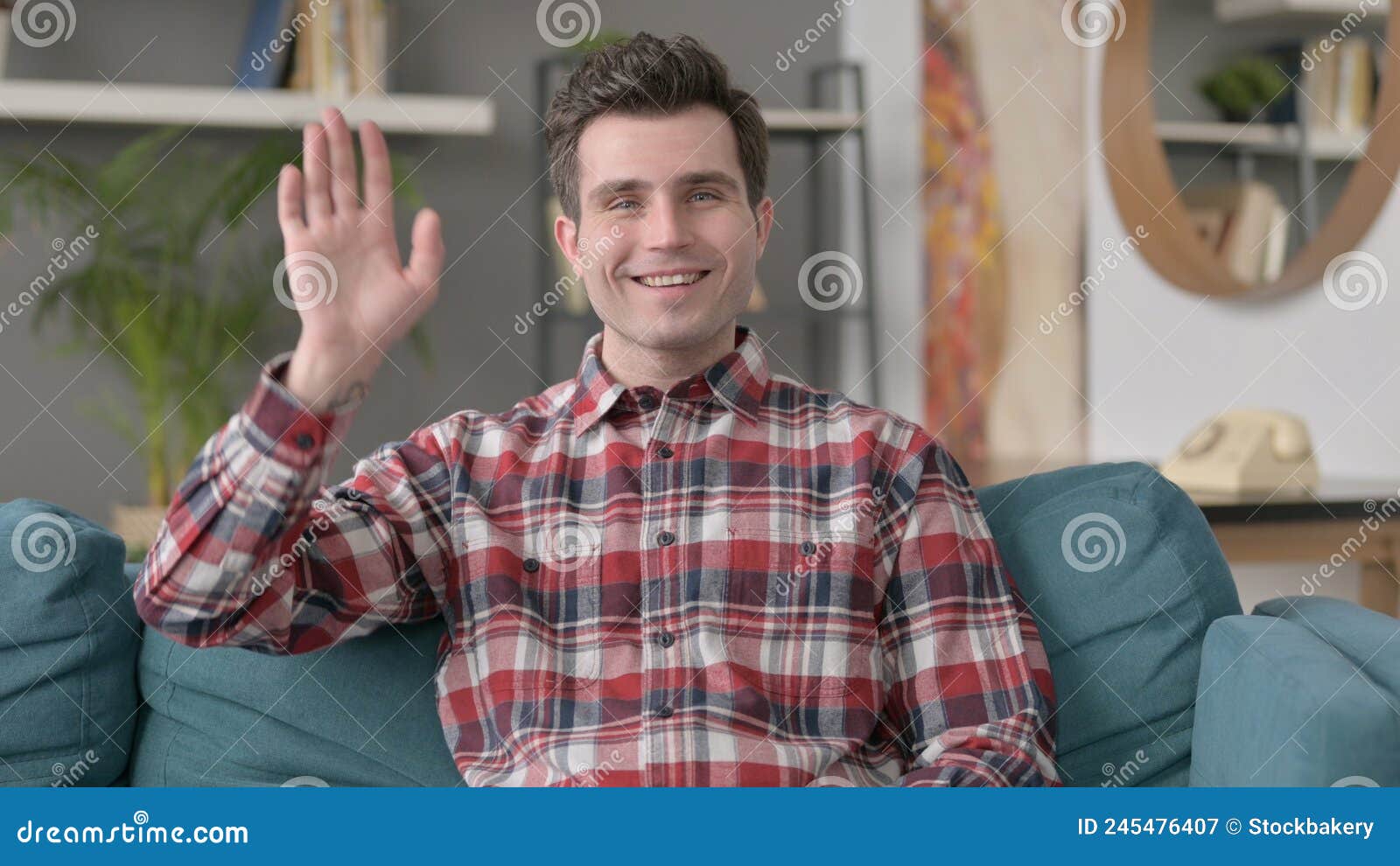 Portrait of Man Waving Towards Camera, Sitting on Sofa Stock Image ...