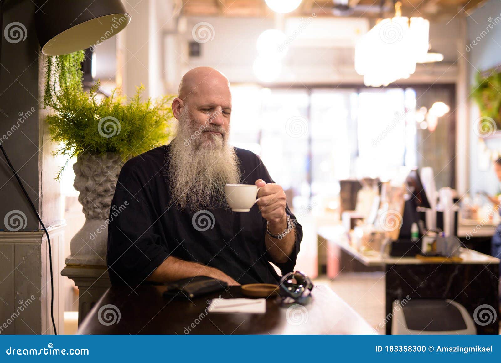 Mature Handsome Bald Bearded Man Drinking Coffee at the Coffee Shop ... Mature Handsome Bald Bearded Man Drinking Coffee at the Coffee Shop ...