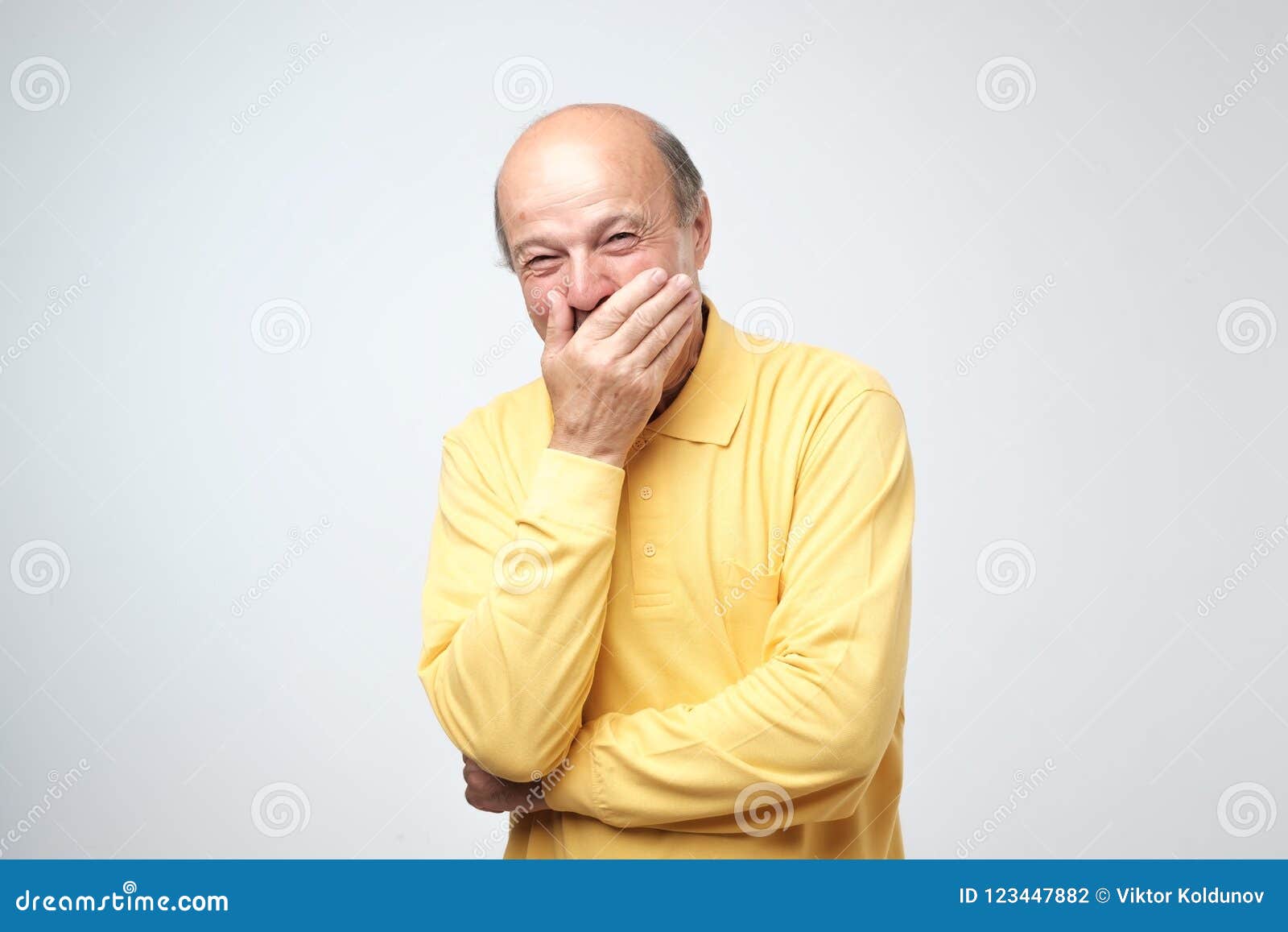 Portrait Of Mature Man Laughing And Covering His Mouth With Hand Over