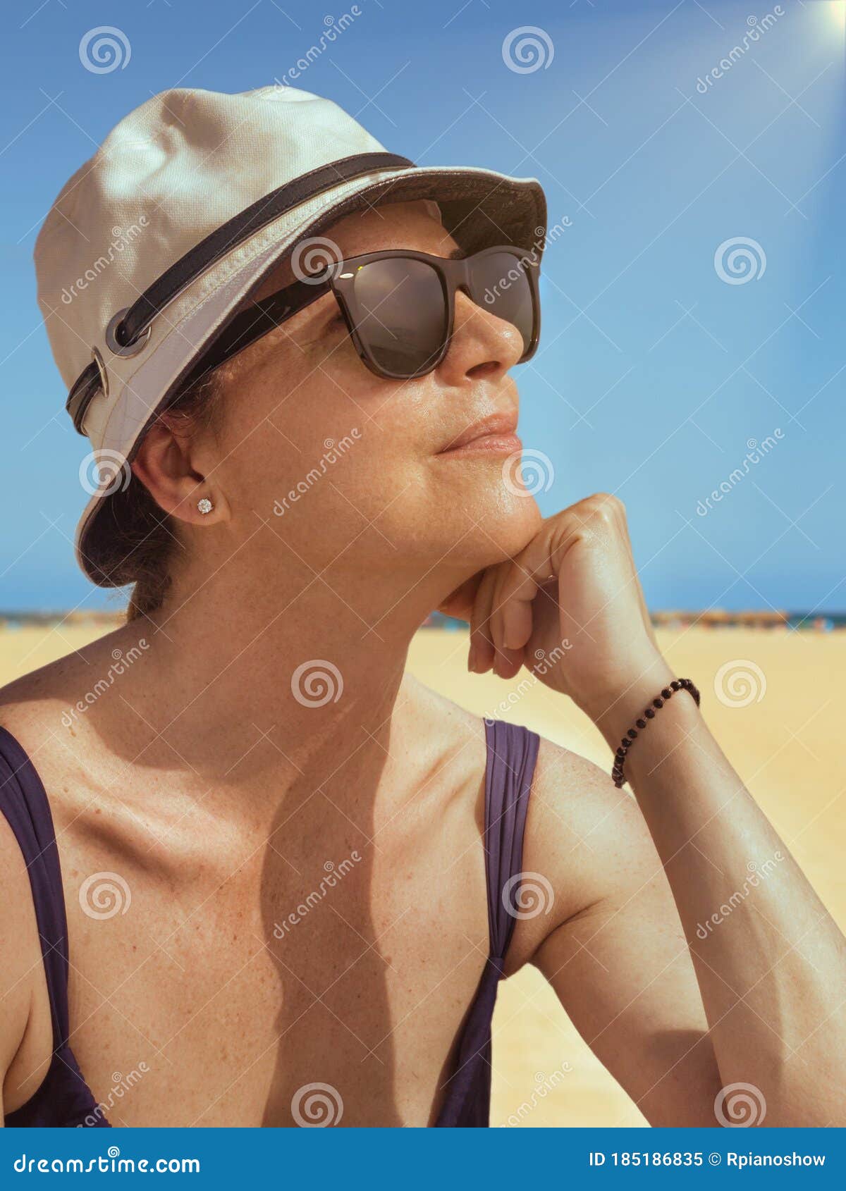 Portrait Of A Mature Woman Wearing Hat And Sunglasses Looking Away At A