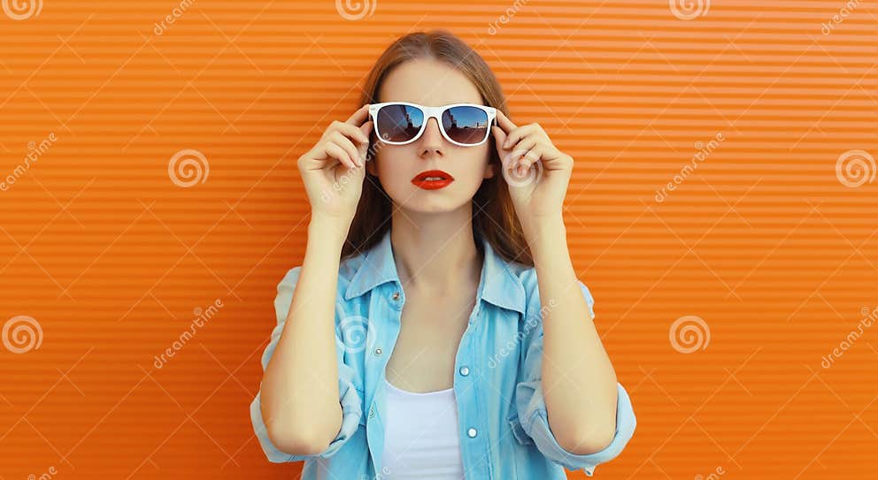 Portrait Of Modern Stylish Young Woman In White Glasses Casual Clothing Posing On Orange