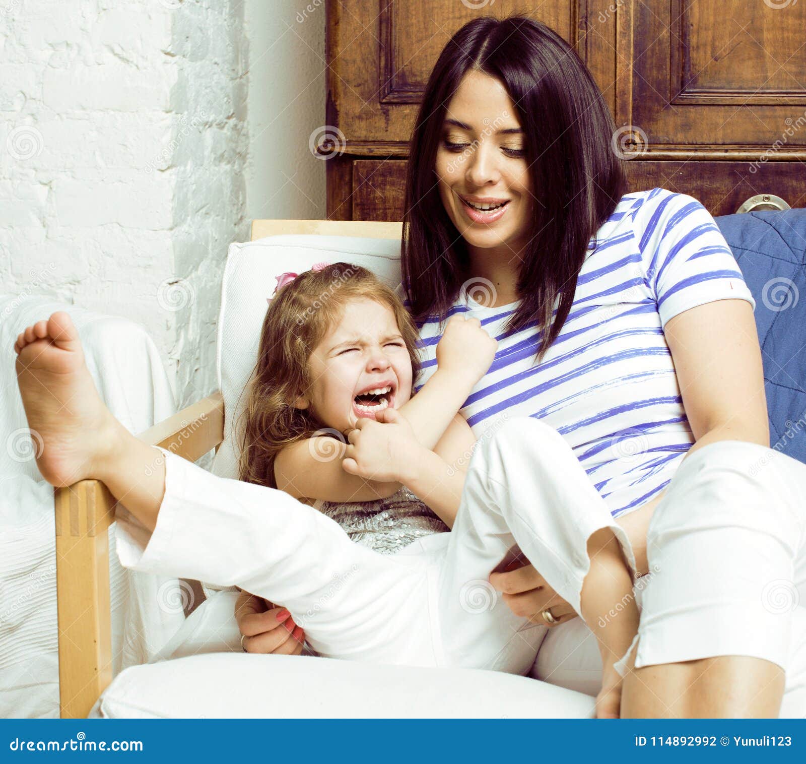 Portrait Of Mother And Daughter Laying In Bed And Smiling Close Stock