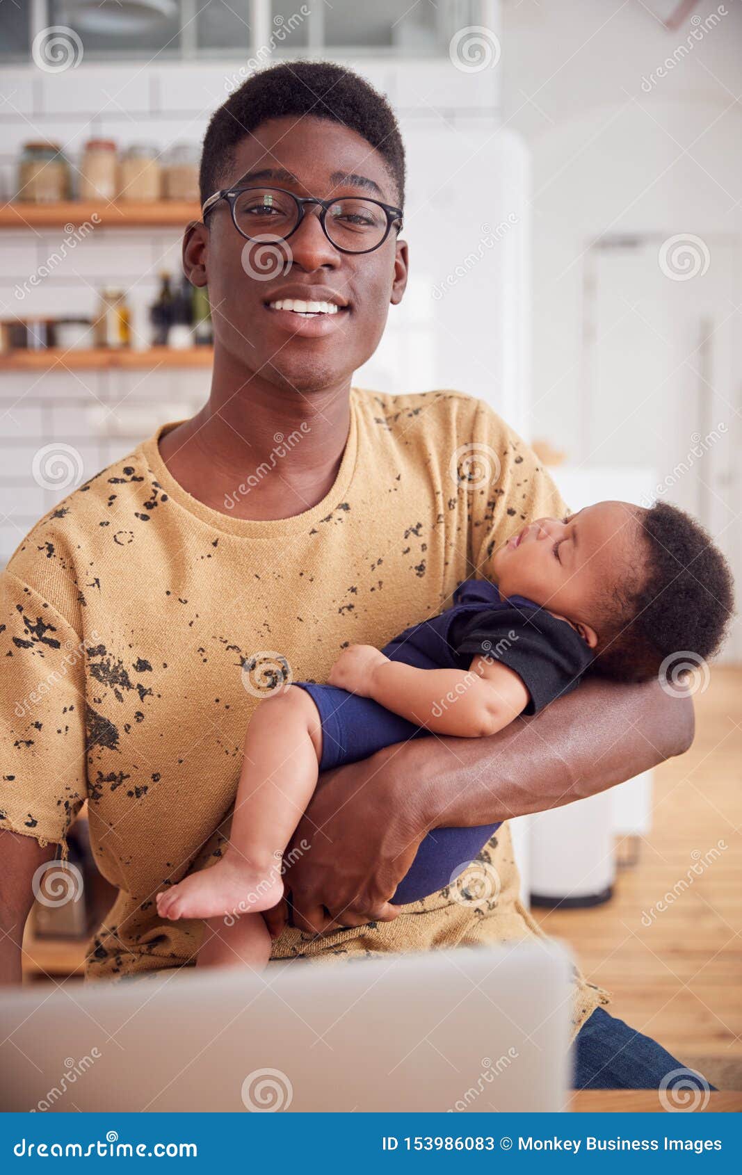 Portrait of Multi-Tasking Father Holding Sleeping Baby Son and Working ...