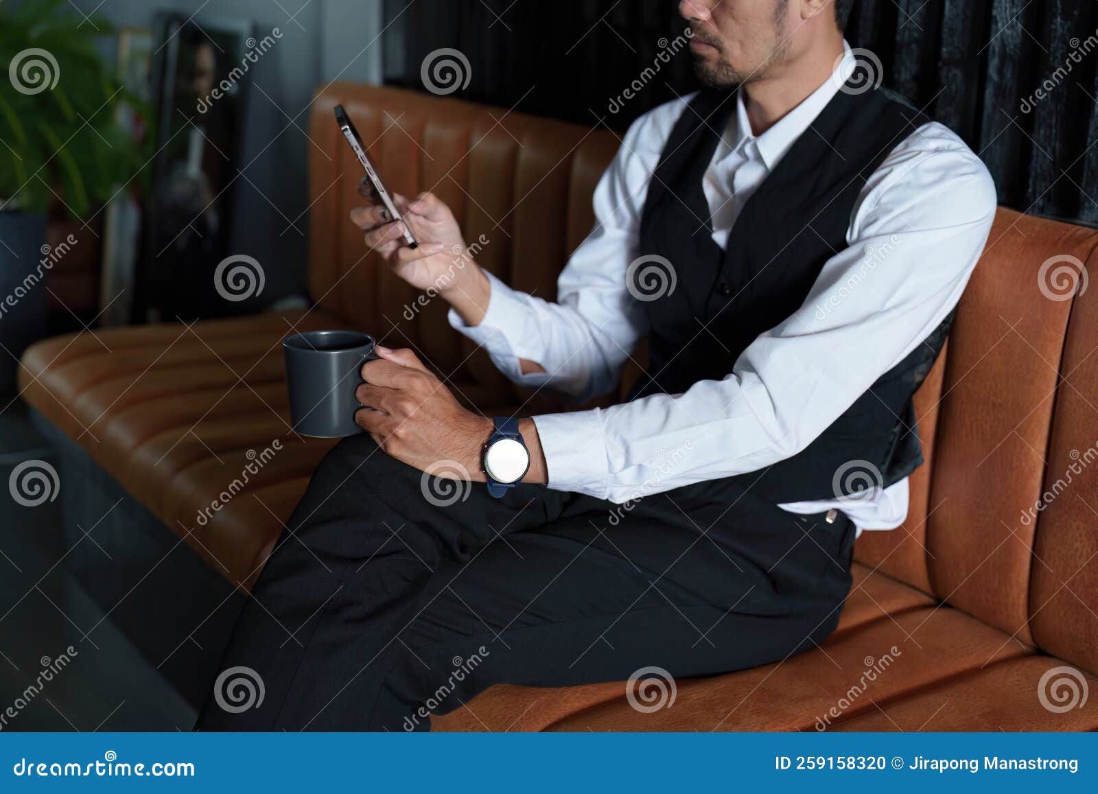 Portrait of a Nice and Discreet Asian Man Sitting on a Sofa Using a ...
