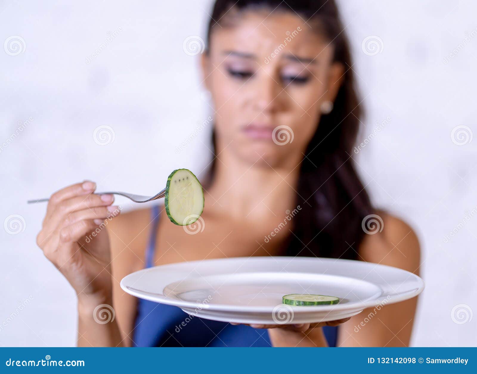 Depressed Dieting Woman Holding Folk Looking At Small Green Vegetable