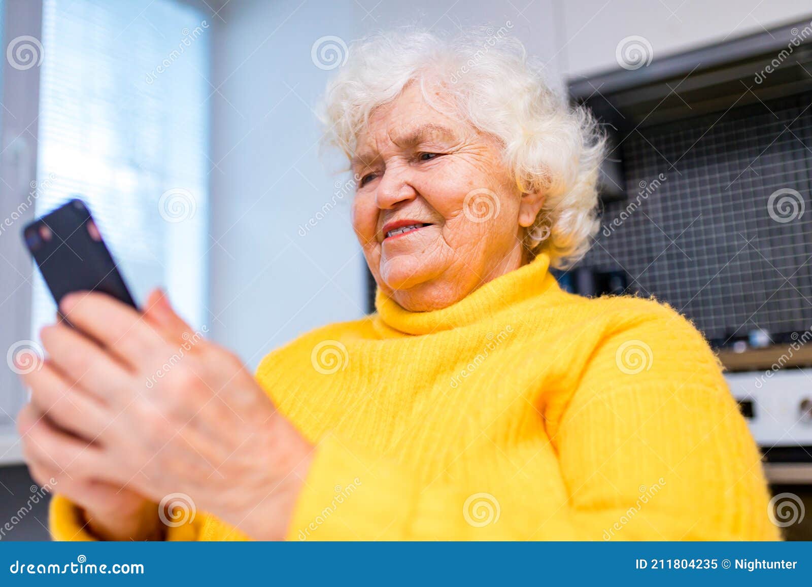 Portrait of Old Smiling Lady Looking at Screen of Mobile Phone Stock ...
