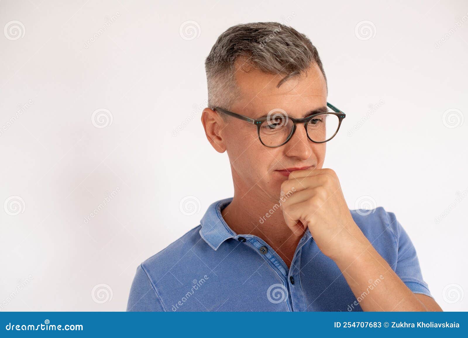 Portrait Of Pensive Mature Man Wearing Glasses With Hand On Chin Stock