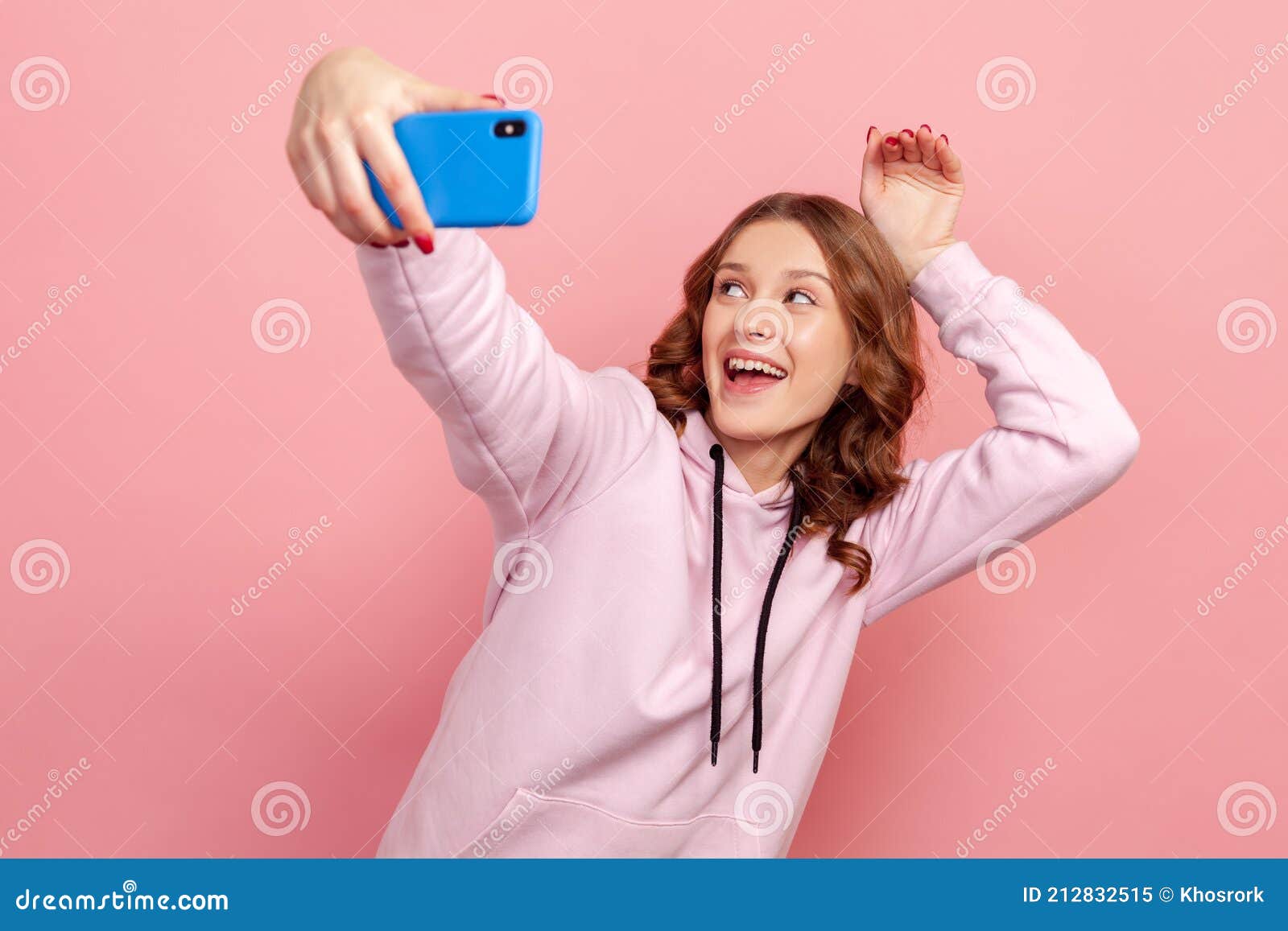 Portrait Of Playful Teenage Girl In Hoodie Gesturing Bunny Ears And