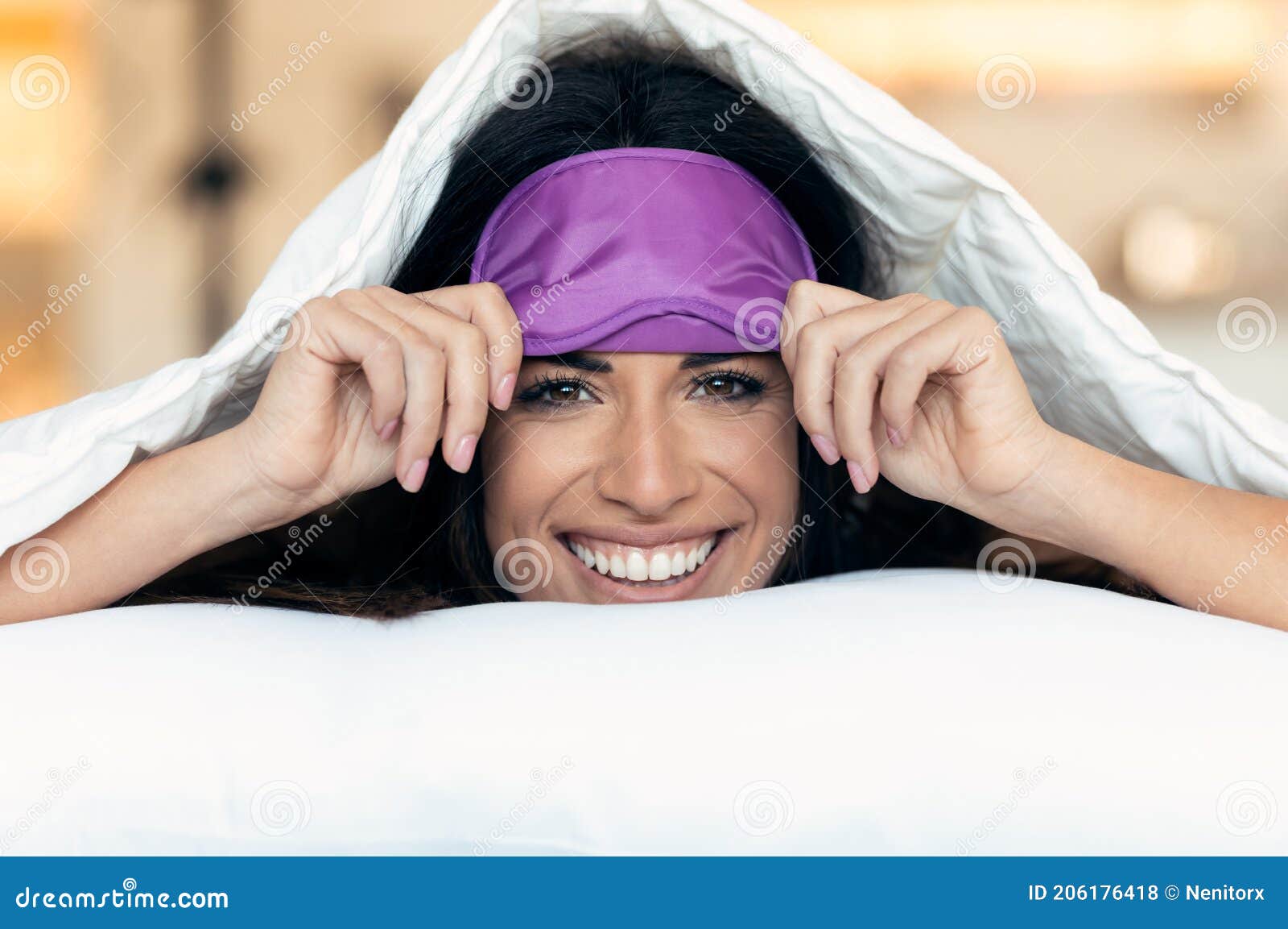 Pretty Young Woman Pulling Up Sleeping Mask While Looking At Camera