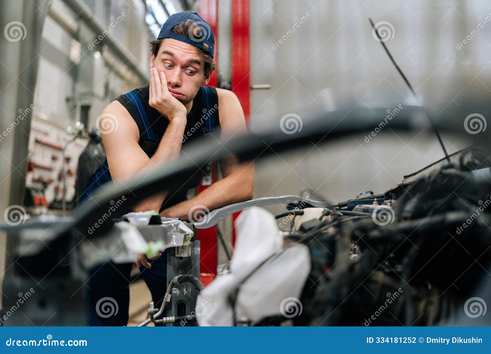 Portrait of Puzzled Mechanic Male with Confused Expression Leaning on ...