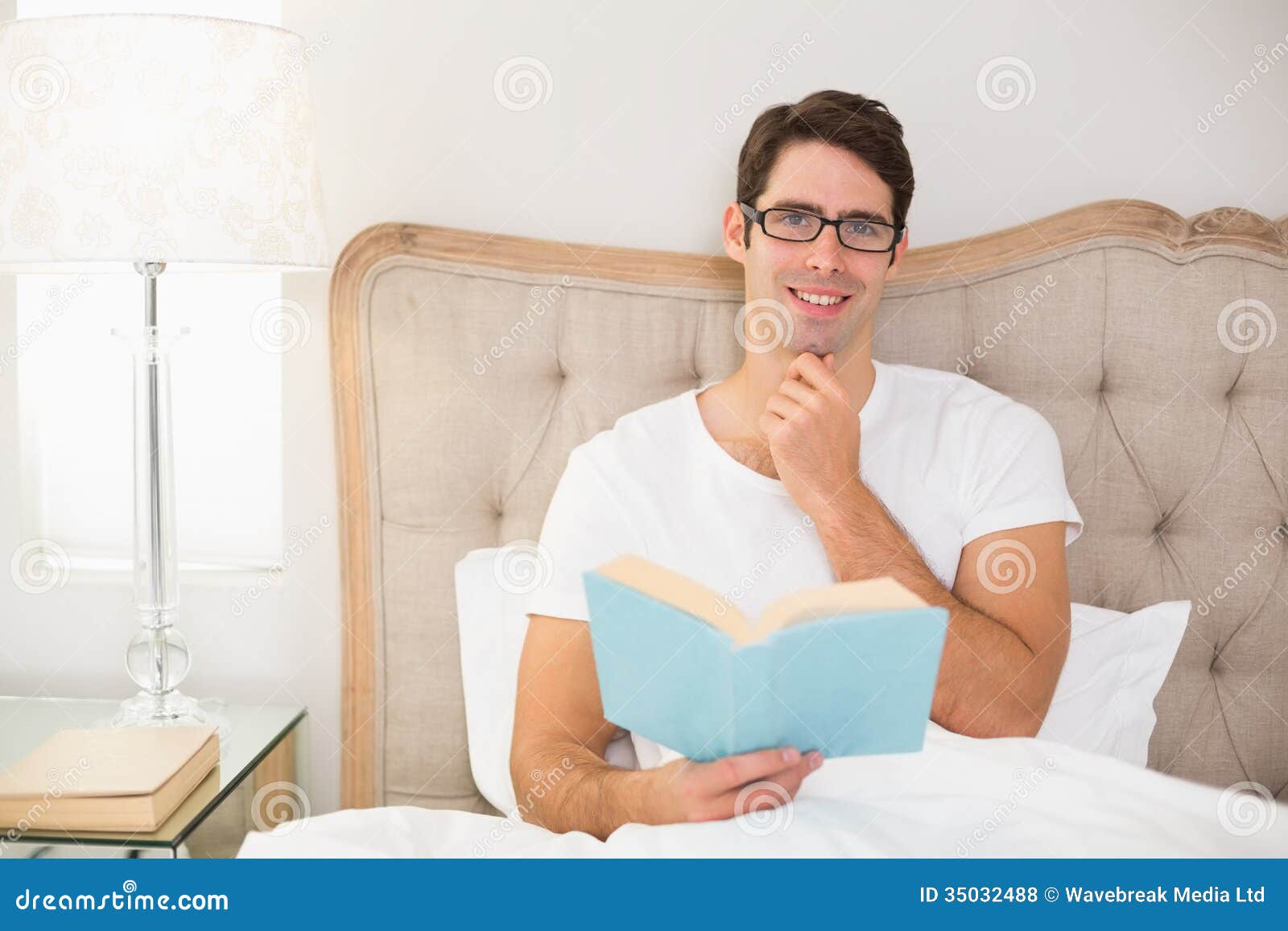 Portrait of Relaxed Man Reading Book in Bed Stock Photo - Image of ...