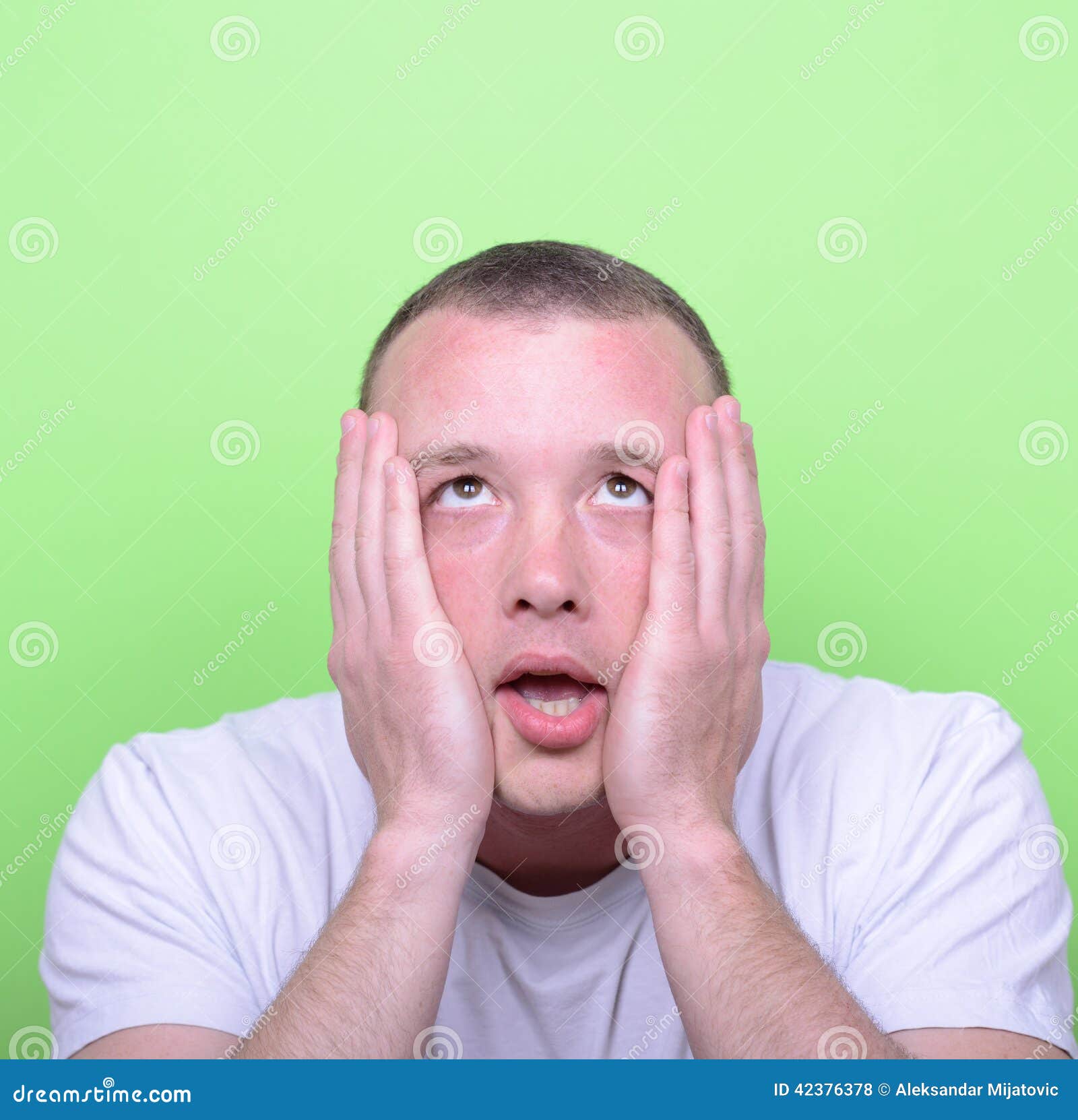 Portrait of Sad Man Looking Up Against Green Background Stock Photo ...