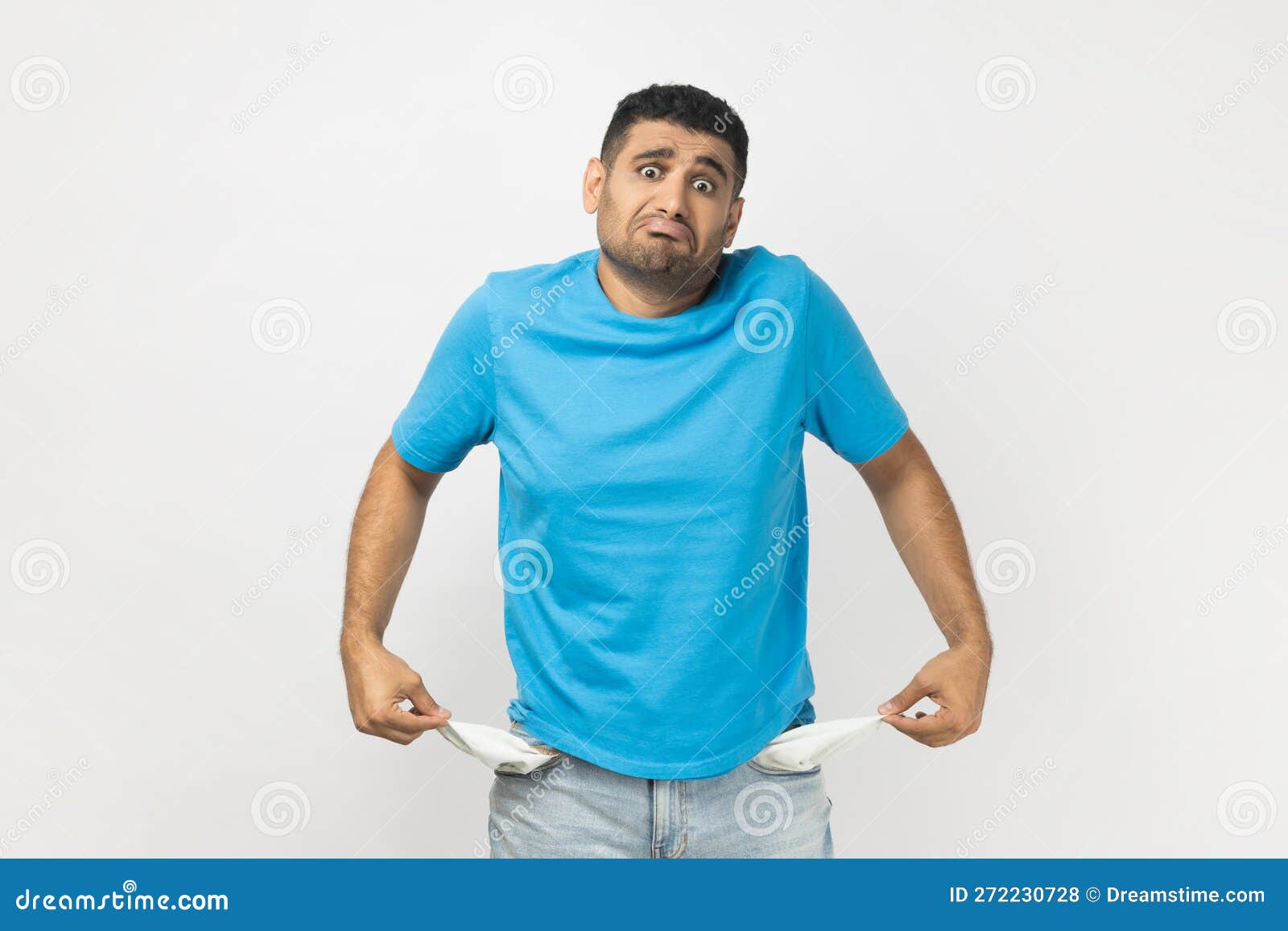 Sad Poor Attractive Man In T Shirt Standing Showing His Empty Pockets