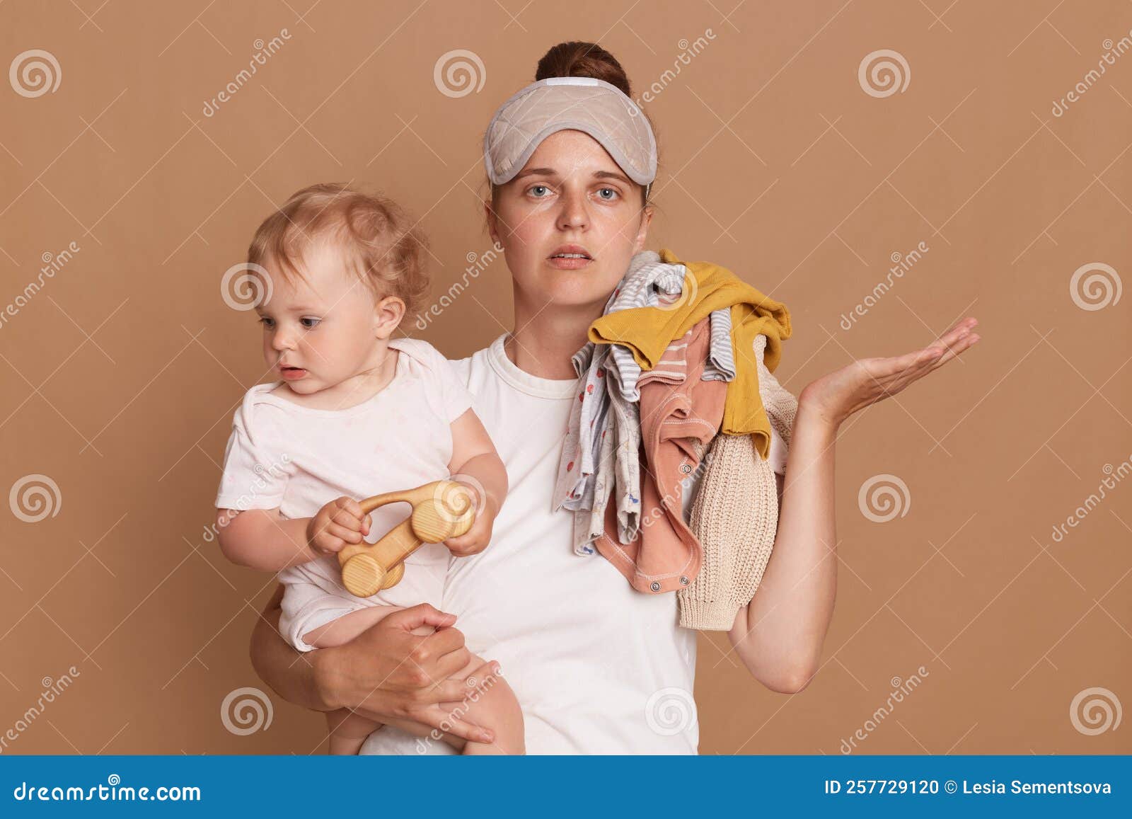 Portrait Of Sad Upset Stressed Young Mother With Bun Hairstyle Holding