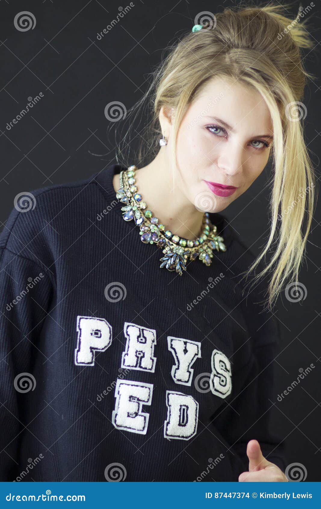 A Portrait Of A Sassy Blond Woman With Blue Eyes And Phys Ed Black Shirt And Necklace Stock