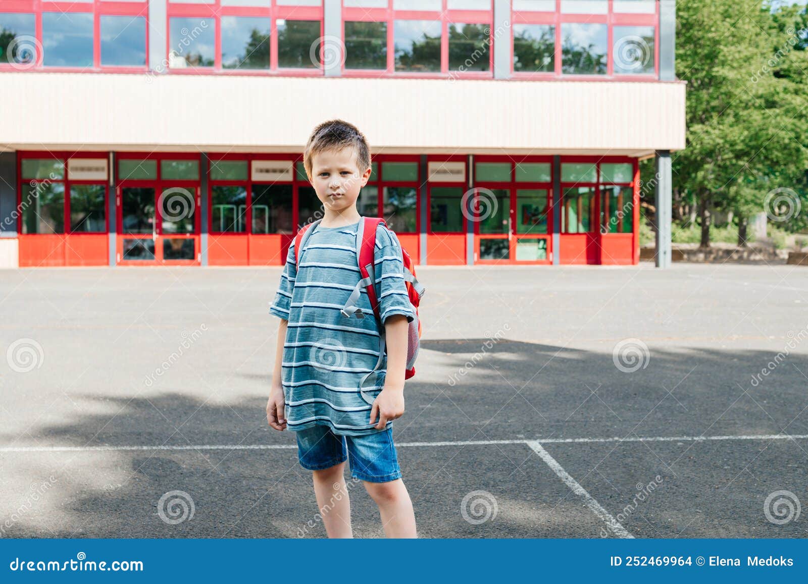 Portrait of a Schoolboy with a Backpack on His Back Standing Against ...