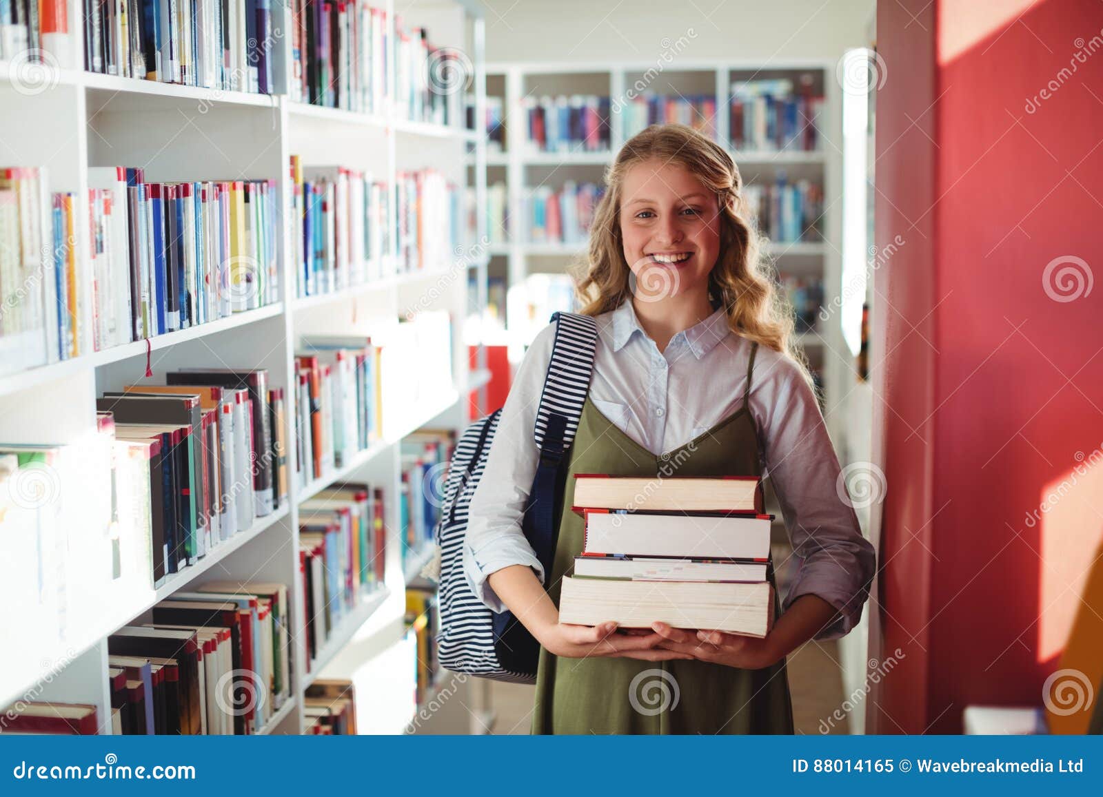 Portrait of Schoolgirl Standing with Stack of Books in Library Stock ...