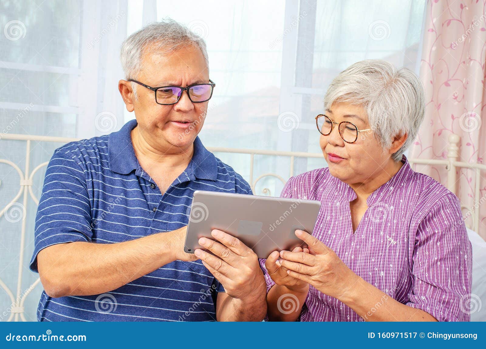 Portrait of Senior Couple Feeling Concerned Using Electronic Tablet at ...