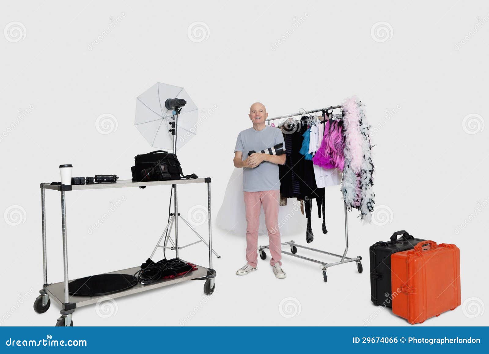 Portrait of Senior Photographer Standing in Front of Clothes Rack in ...