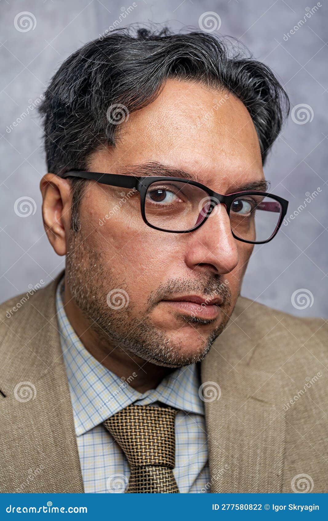 Portrait Of A Serious Dark Haired Man With Stubble In Glasses Jacket