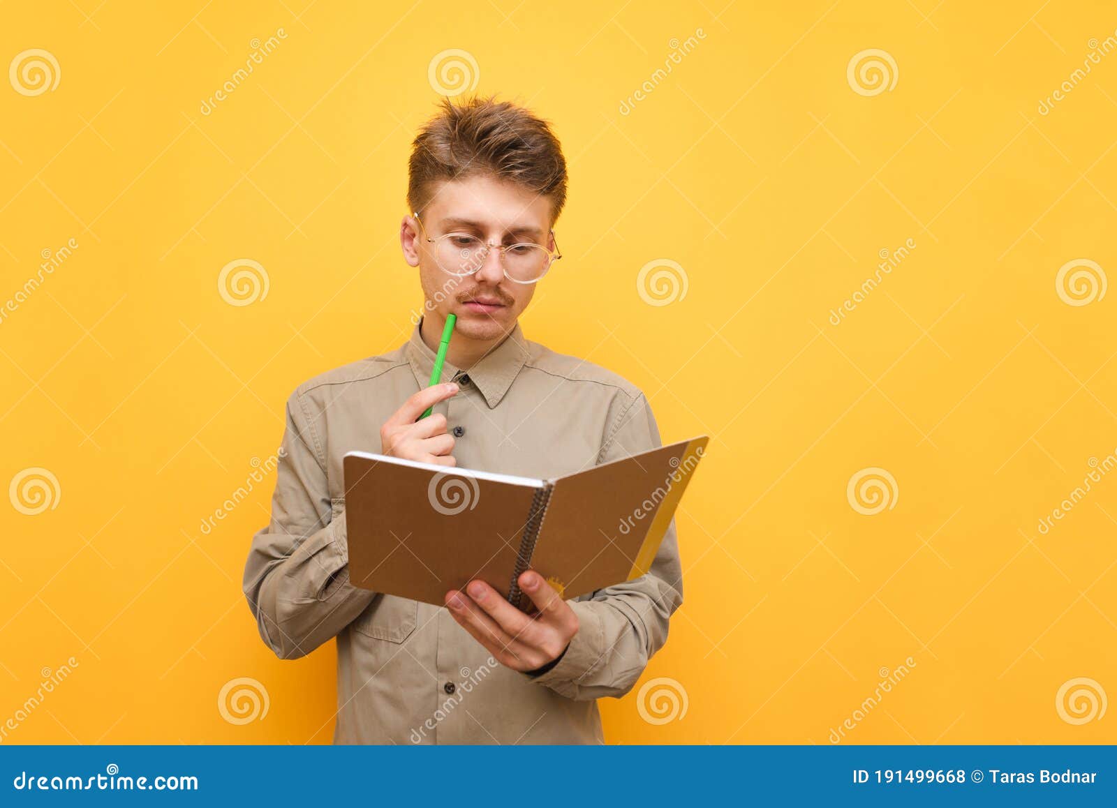 Portrait of Serious Student with Notepad and Pen in Hand, Looking ...