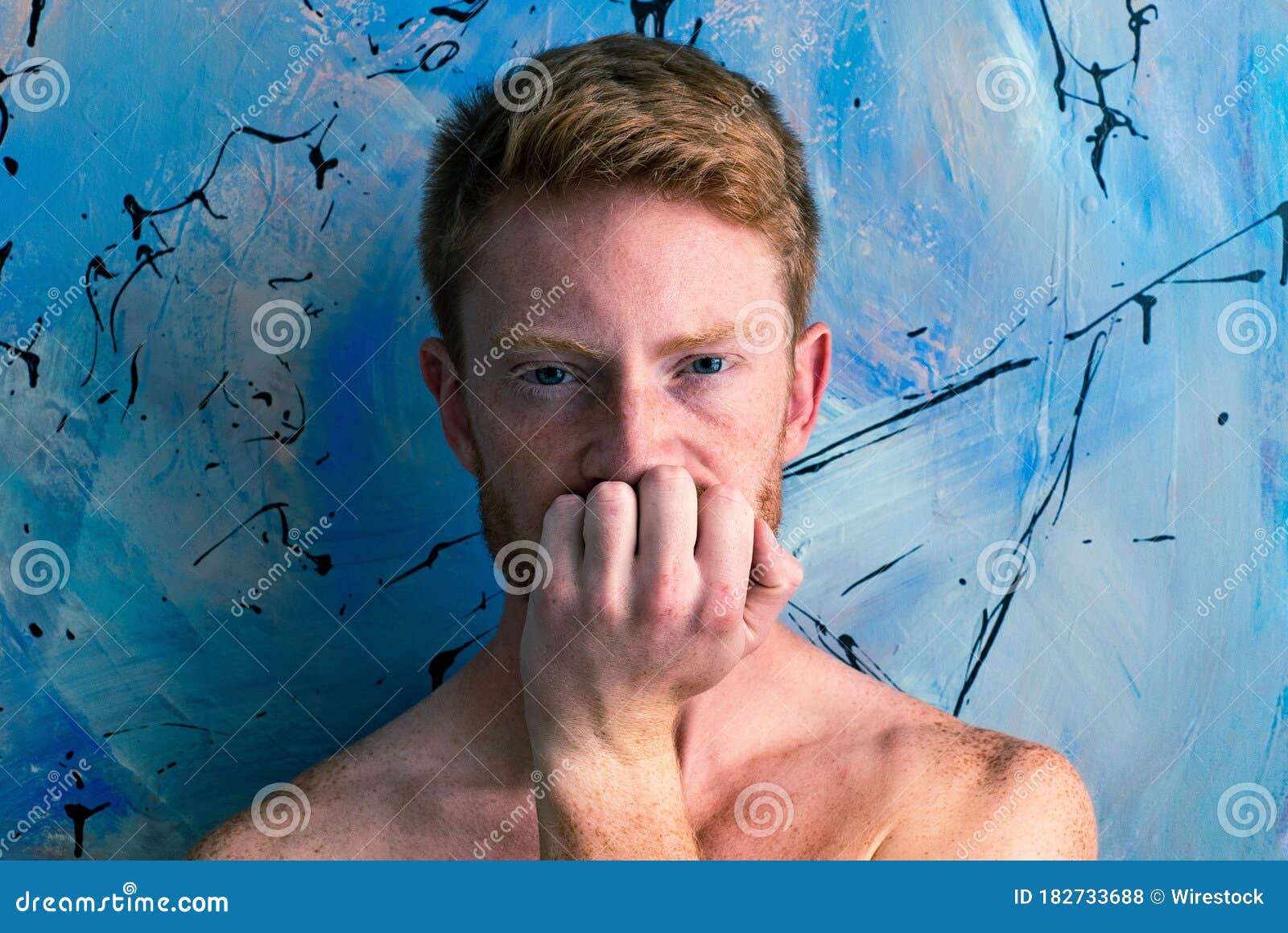 Portrait Of A Shirtless Handsome Man Covering His Mouth With An Intense