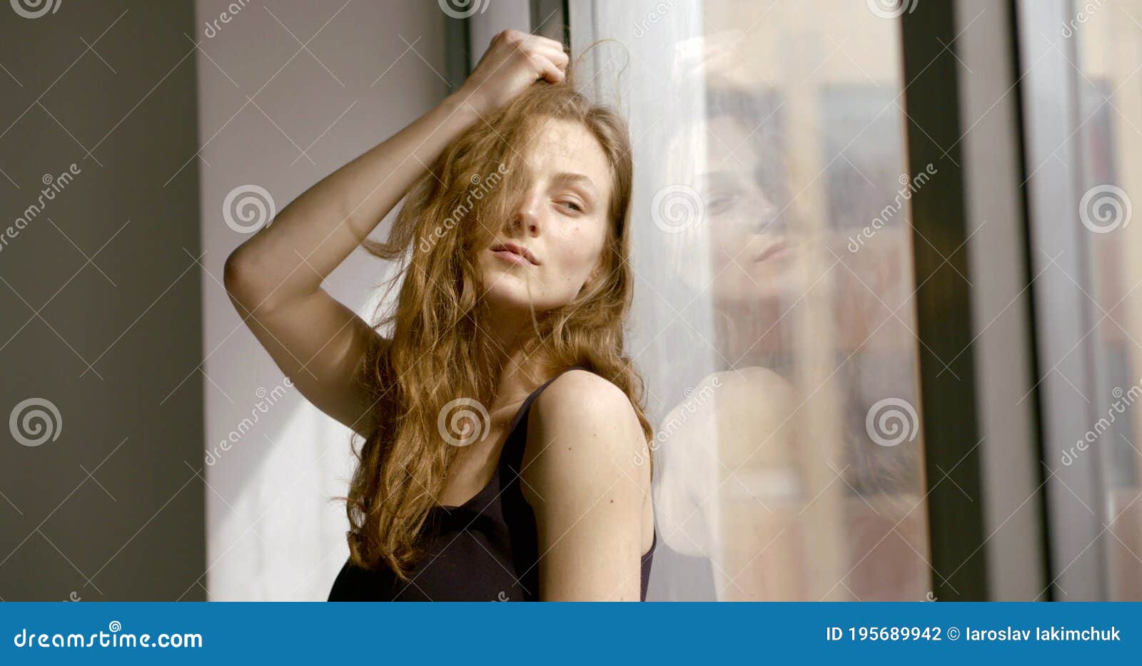 Portrait of a Slender Model Posing on the Windowsill of a Large ...