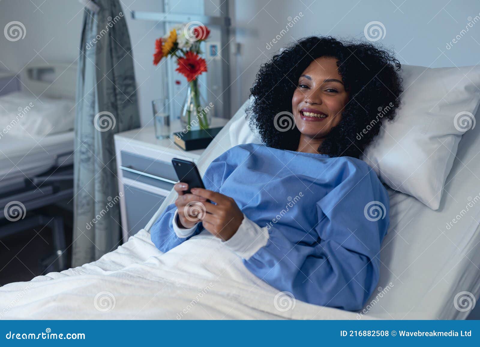 Portrait Of Smiling African American Female Patient Lying In Hospital