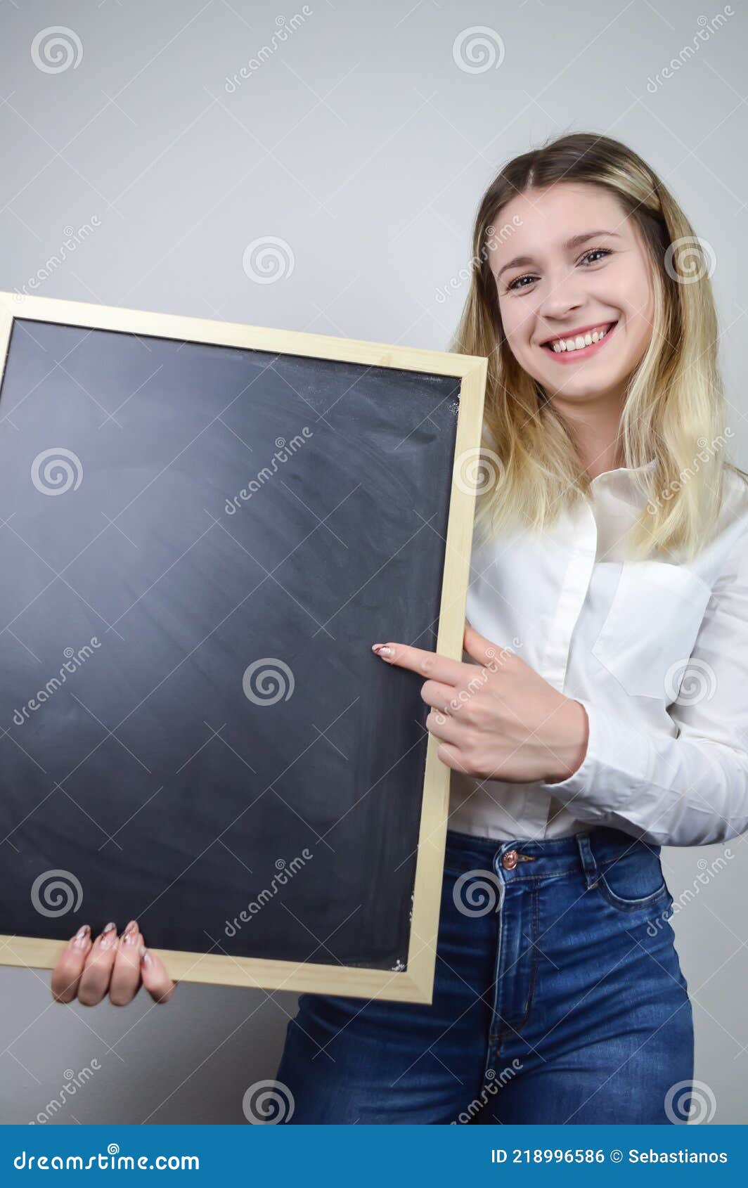 Portrait Of A Smiling Beautiful Young Blonde Woman Holding An Empty