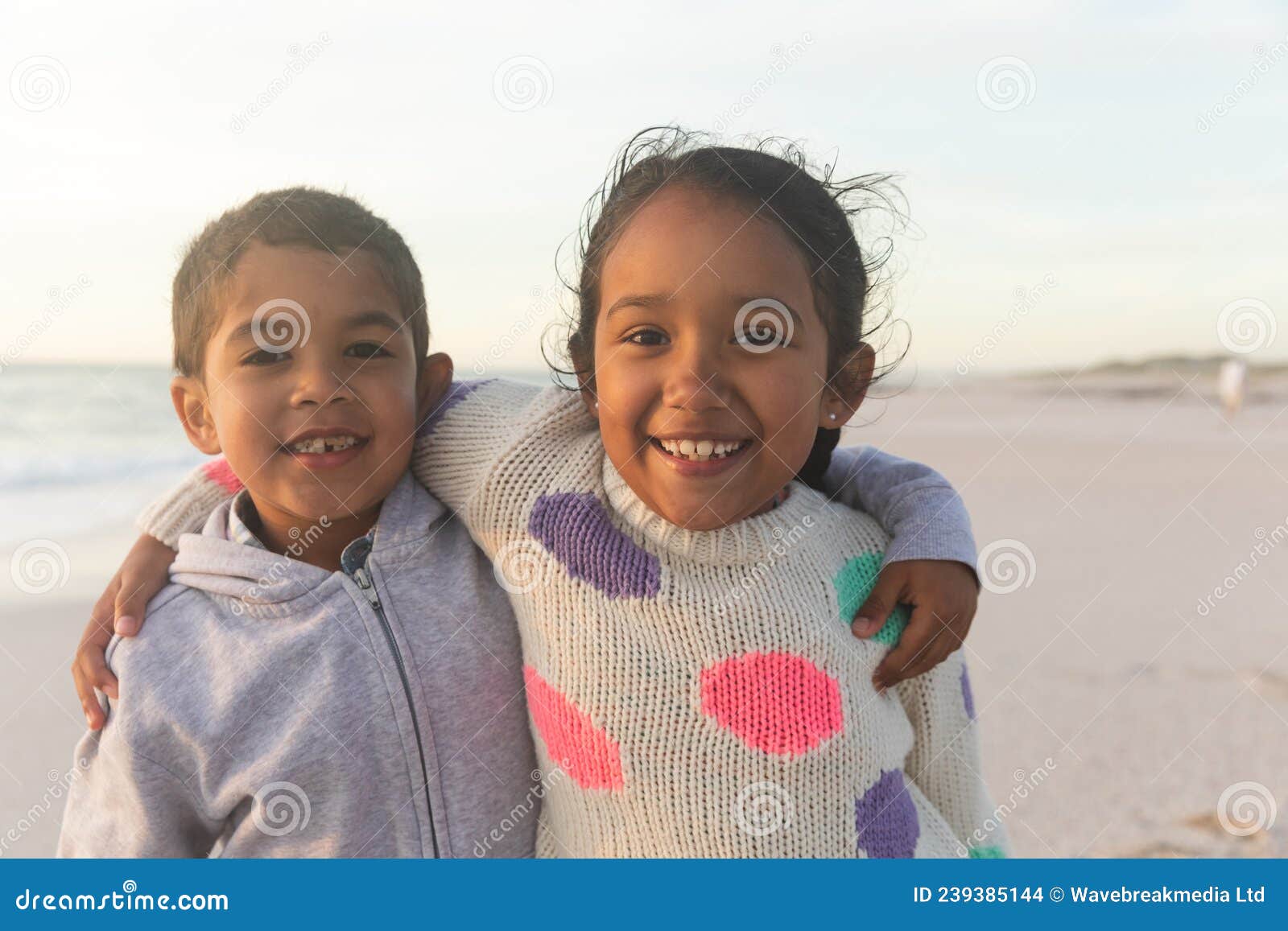 Portrait Of Smiling Biracial Brother And Sister Standing With Arms