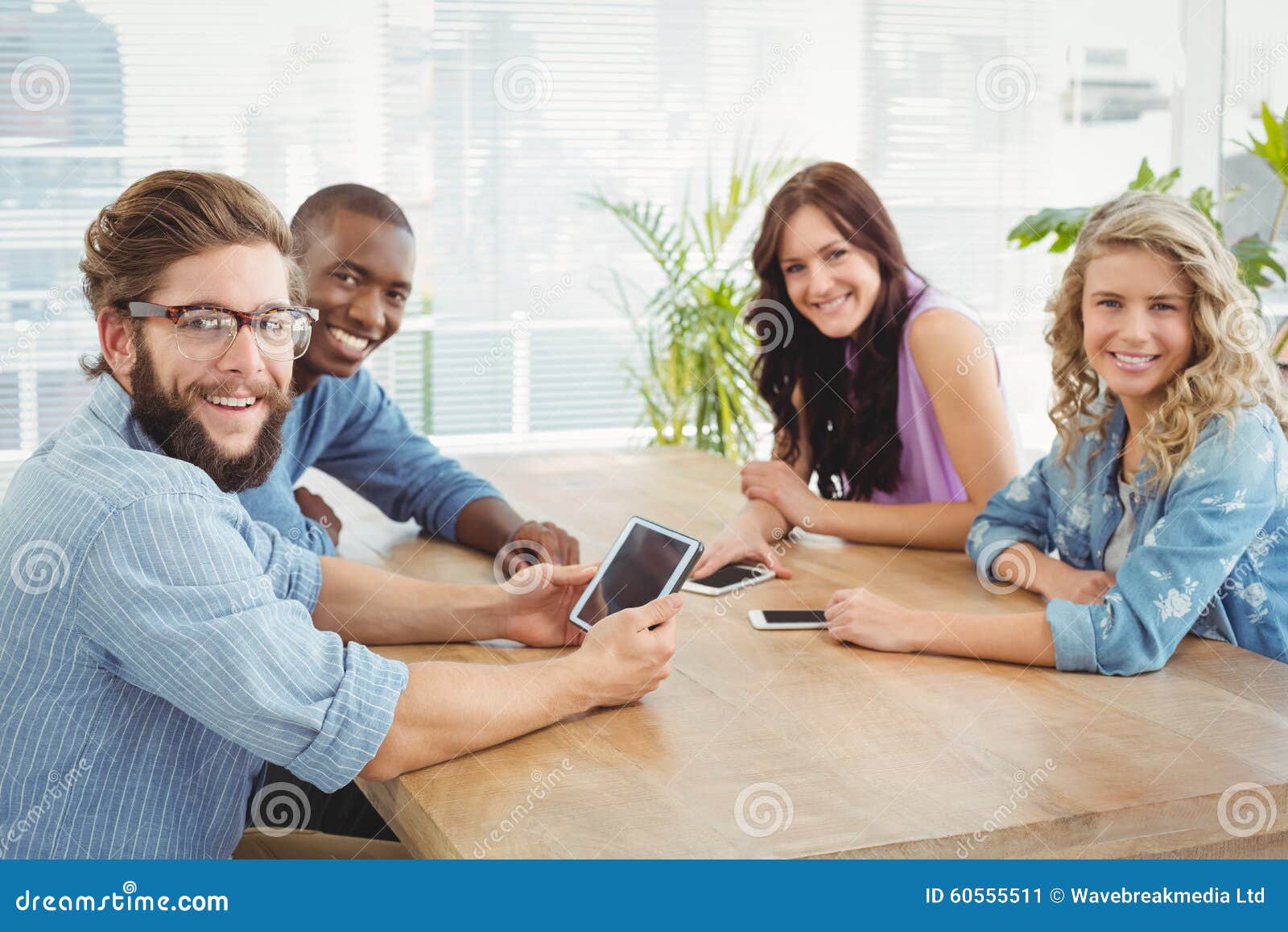 Portrait of Smiling Business Professionals Using Technology at Desk ...