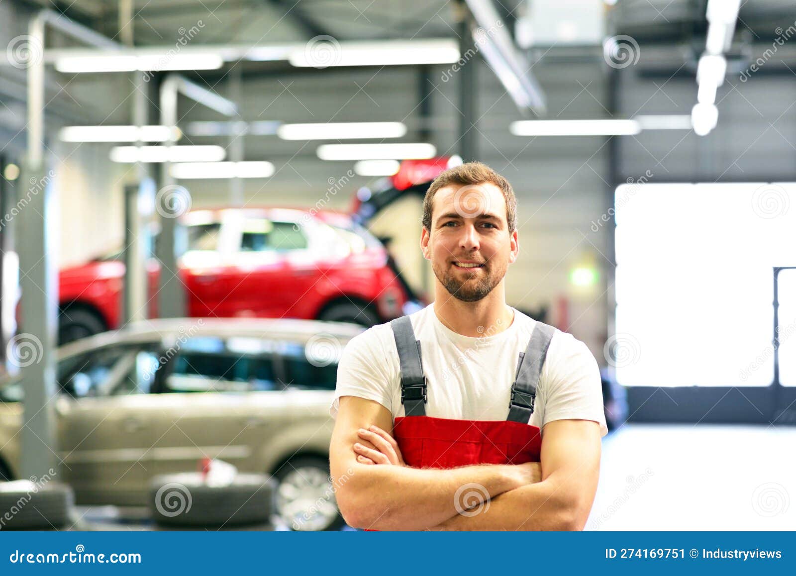 Portrait of a Smiling Car Mechanic in Car Workshop in Woking Clothes ...