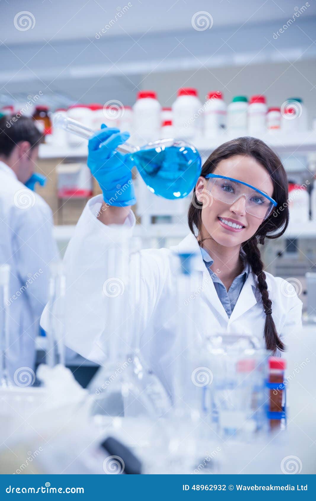 Portrait of a Smiling Chemist Holding a Beaker of Blue Liquid Stock ...