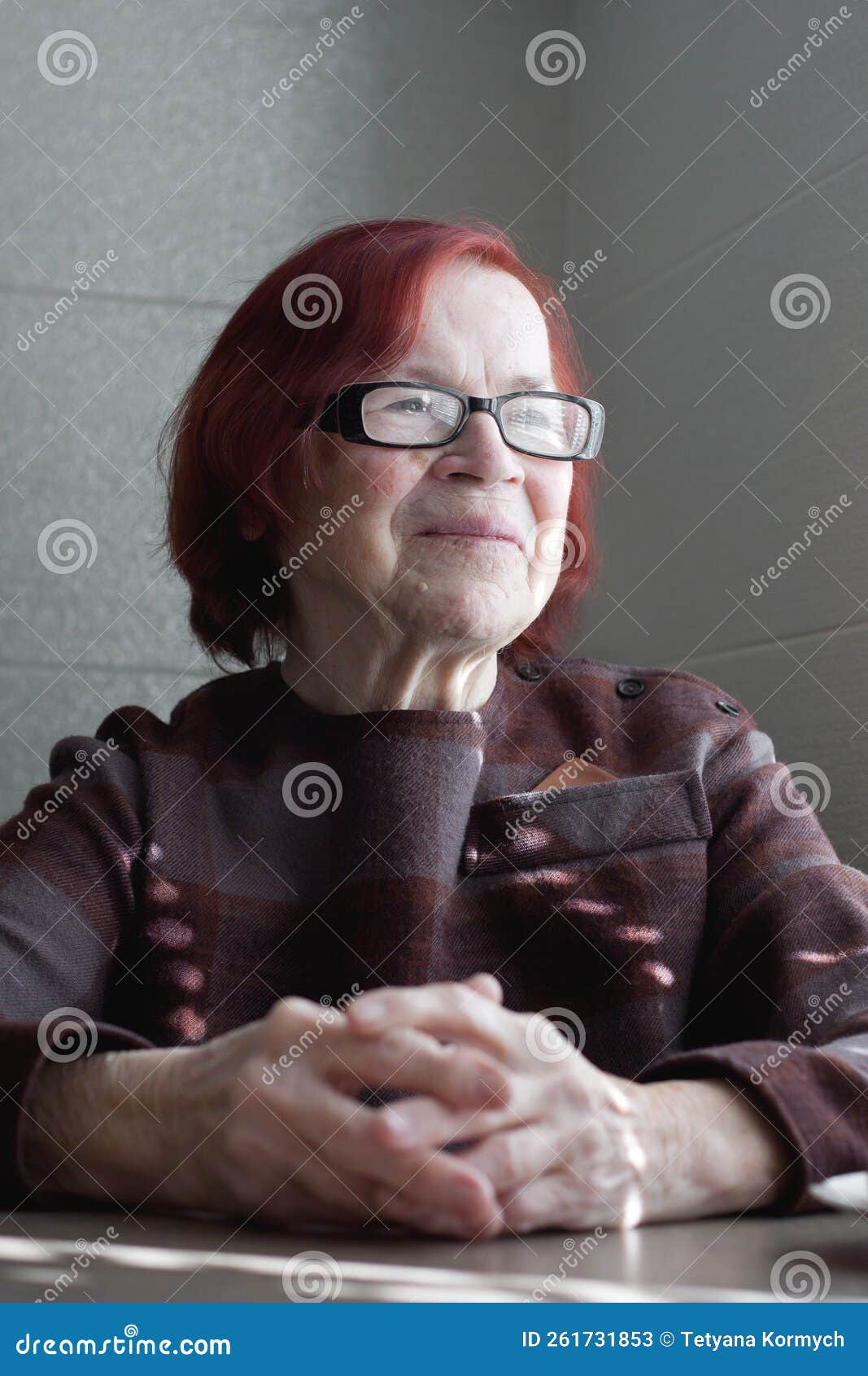Portrait Of A Smiling Elderly Woman With Red Hair Wearing Glasses