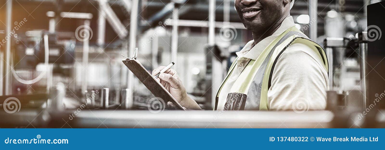 Portrait of Smiling Factory Worker Writing on Clipboard in Factory ...