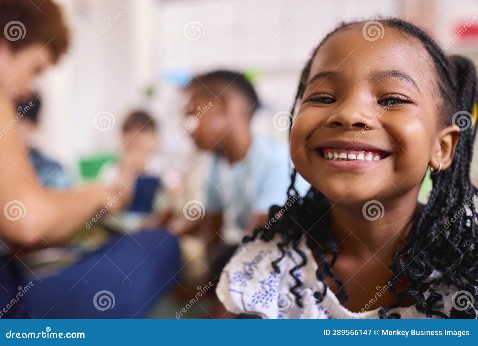 Portrait of Smiling Female Elementary School Pupil Sitting in Classroom ...