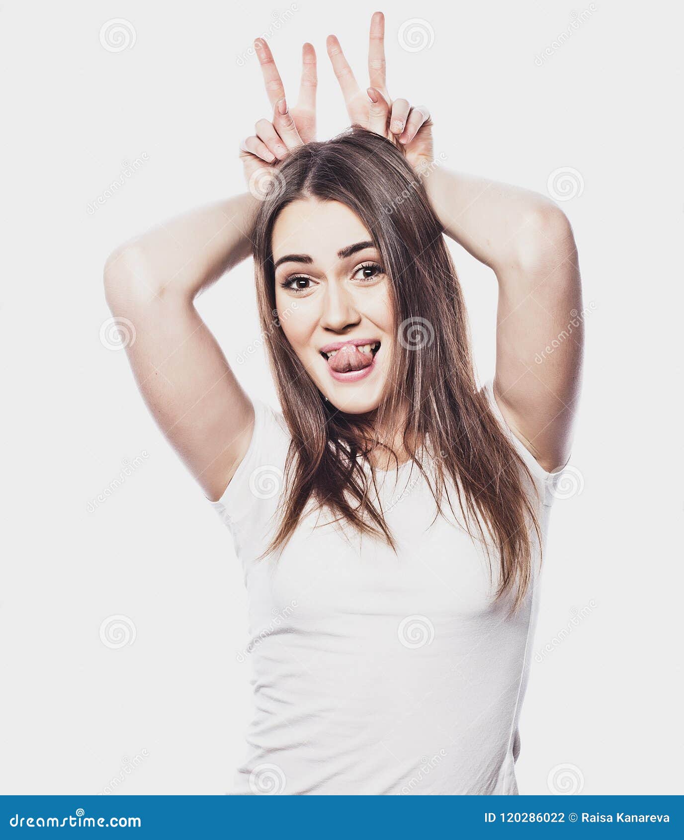 Portrait Of A Smiling Happy Woman Showing Victory Sign And Looking At