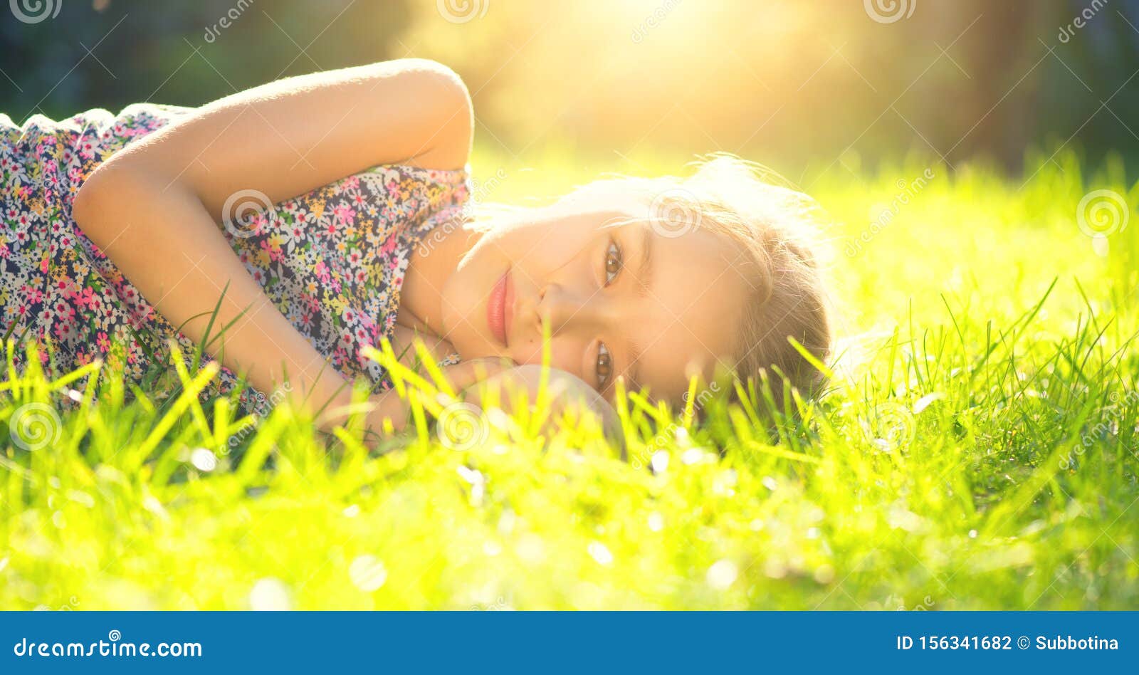 Portrait of a Smiling Little Girl Lying on Green Grass. Cute Six Years ... Portrait of a Smiling Little Girl Lying on Green Grass. Cute Six Years ...