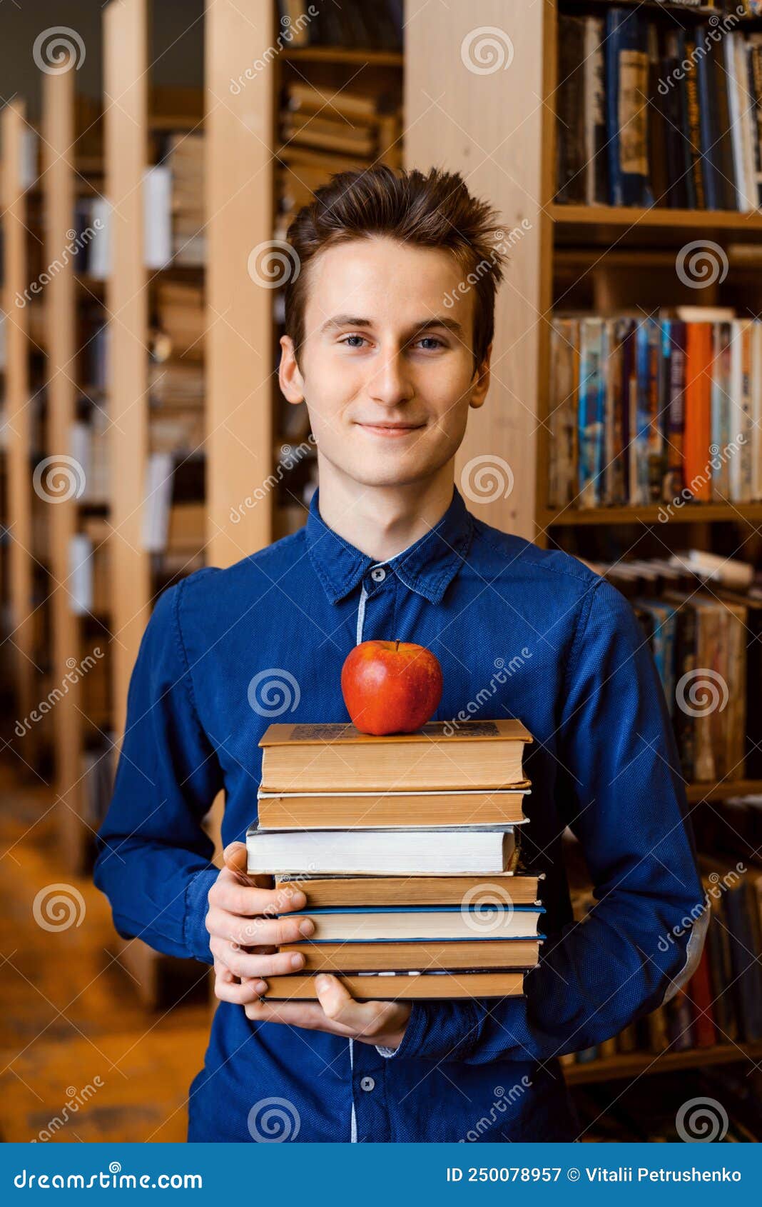 Portrait of a Smiling Male Student Holding a Stack of Books in the ...